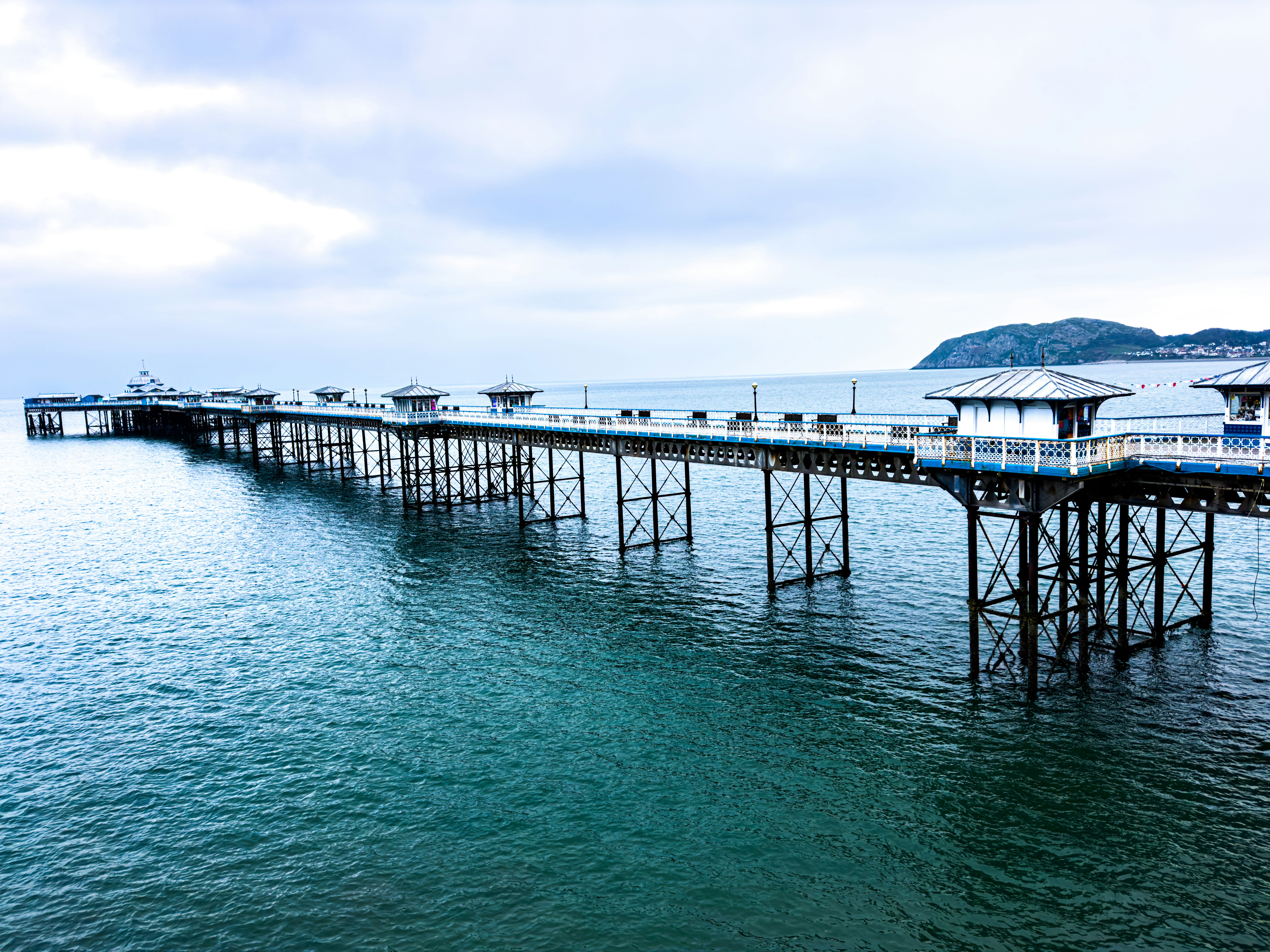 Foto Un muelle en un cuerpo de agua bajo un cielo nublado – Imagen ...
