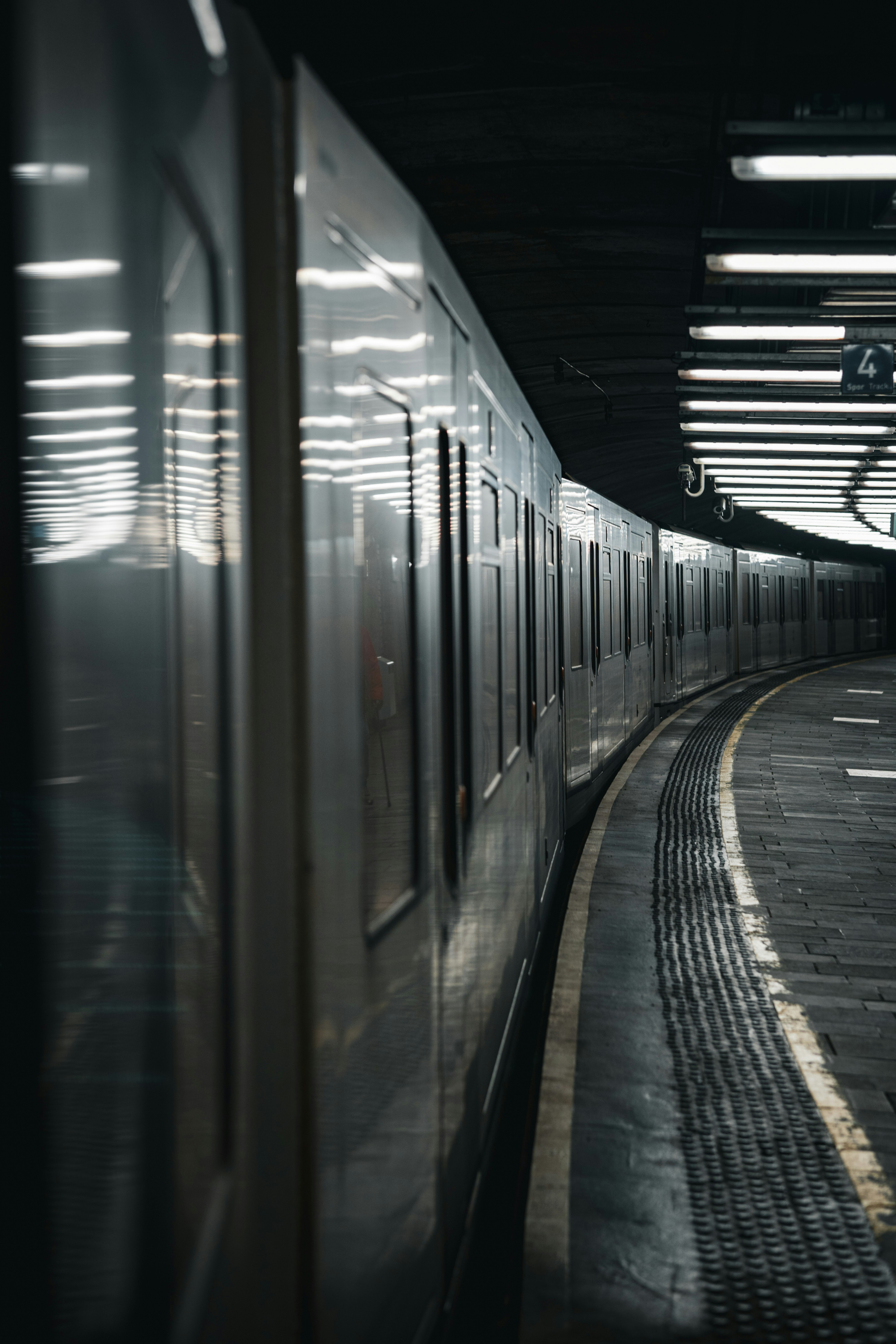 A train traveling through a train station next to a platform photo ...
