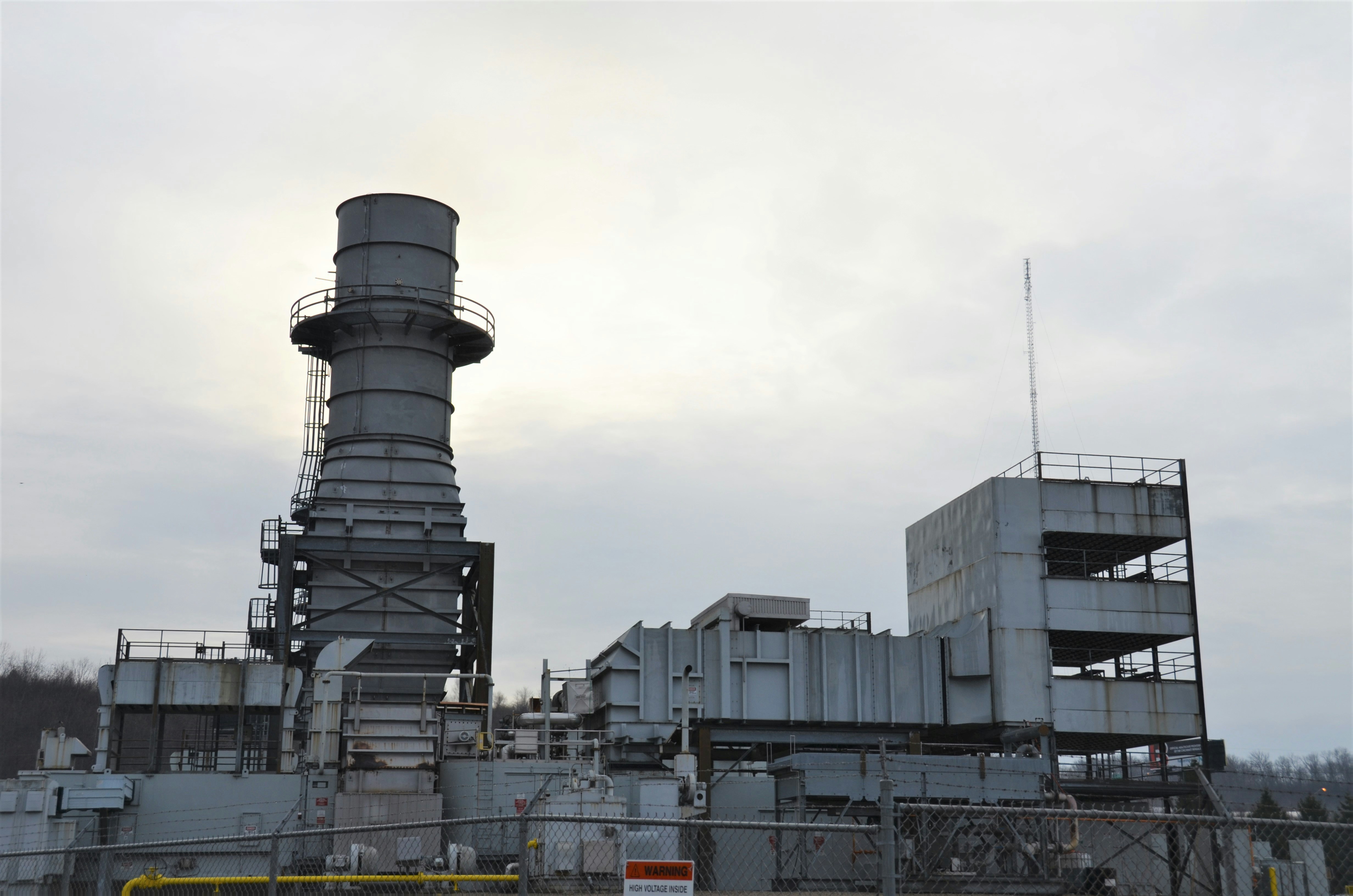 A factory building with a large tower and a fire hydrant photo – Free ...