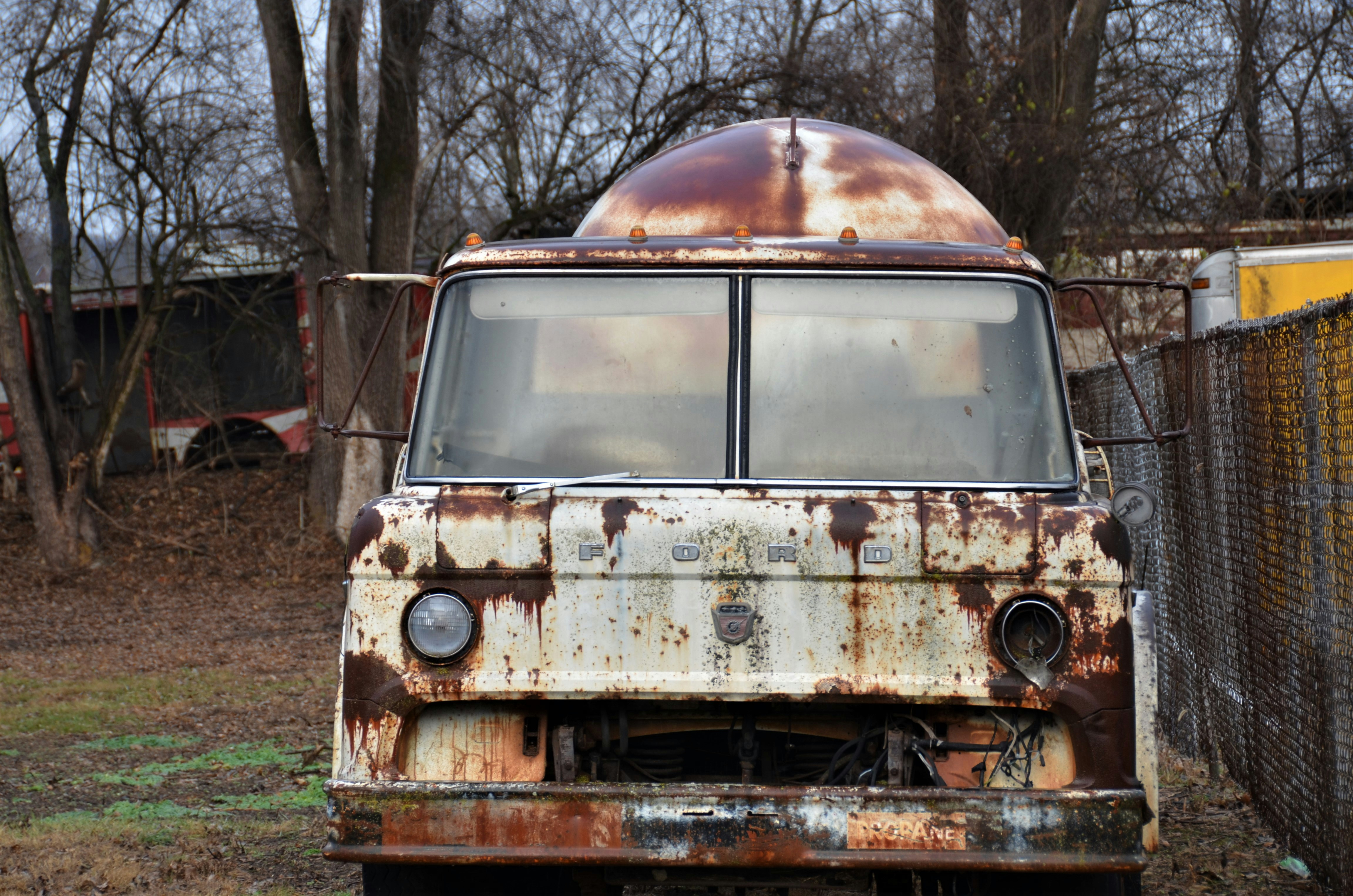 An old rusted out truck sitting in a yard photo – Free Truck Image on ...