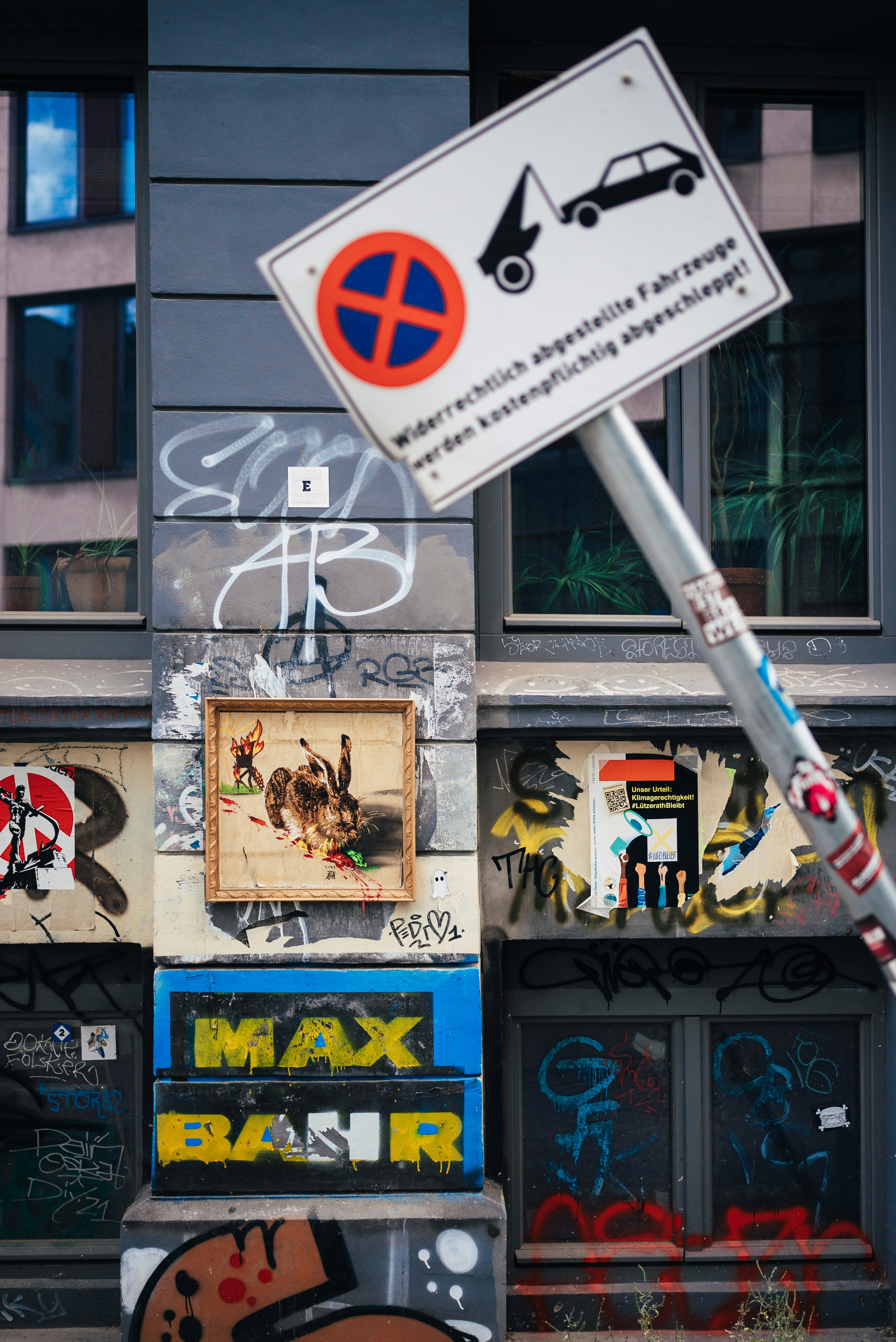 Tilted Traffic Sign Over Graffiti-Wrapped Façade
