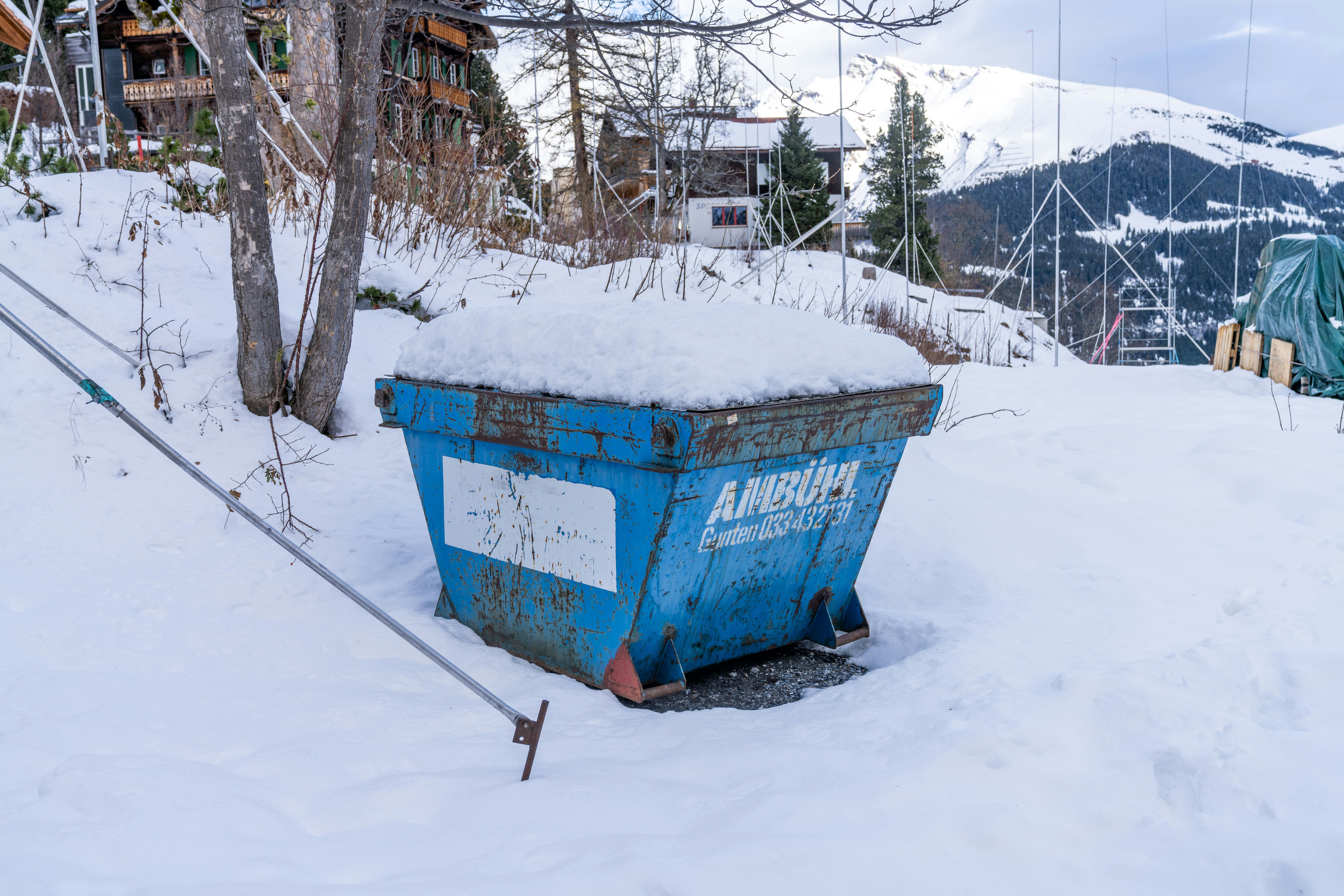 A blue dumpster sitting on top of snow covered ground photo – Free ...