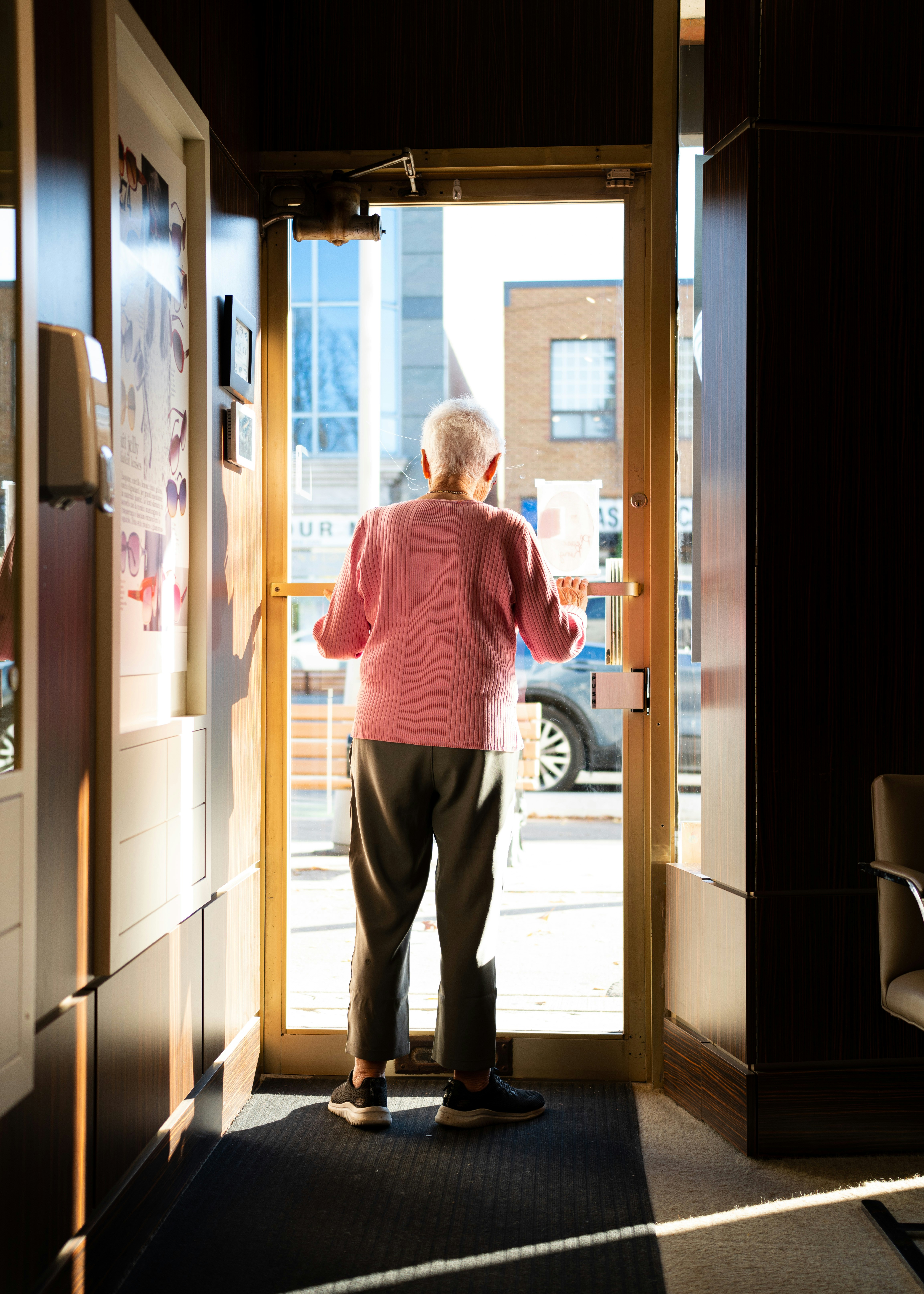 A woman standing in a doorway of a building photo – Free Door Image on ...