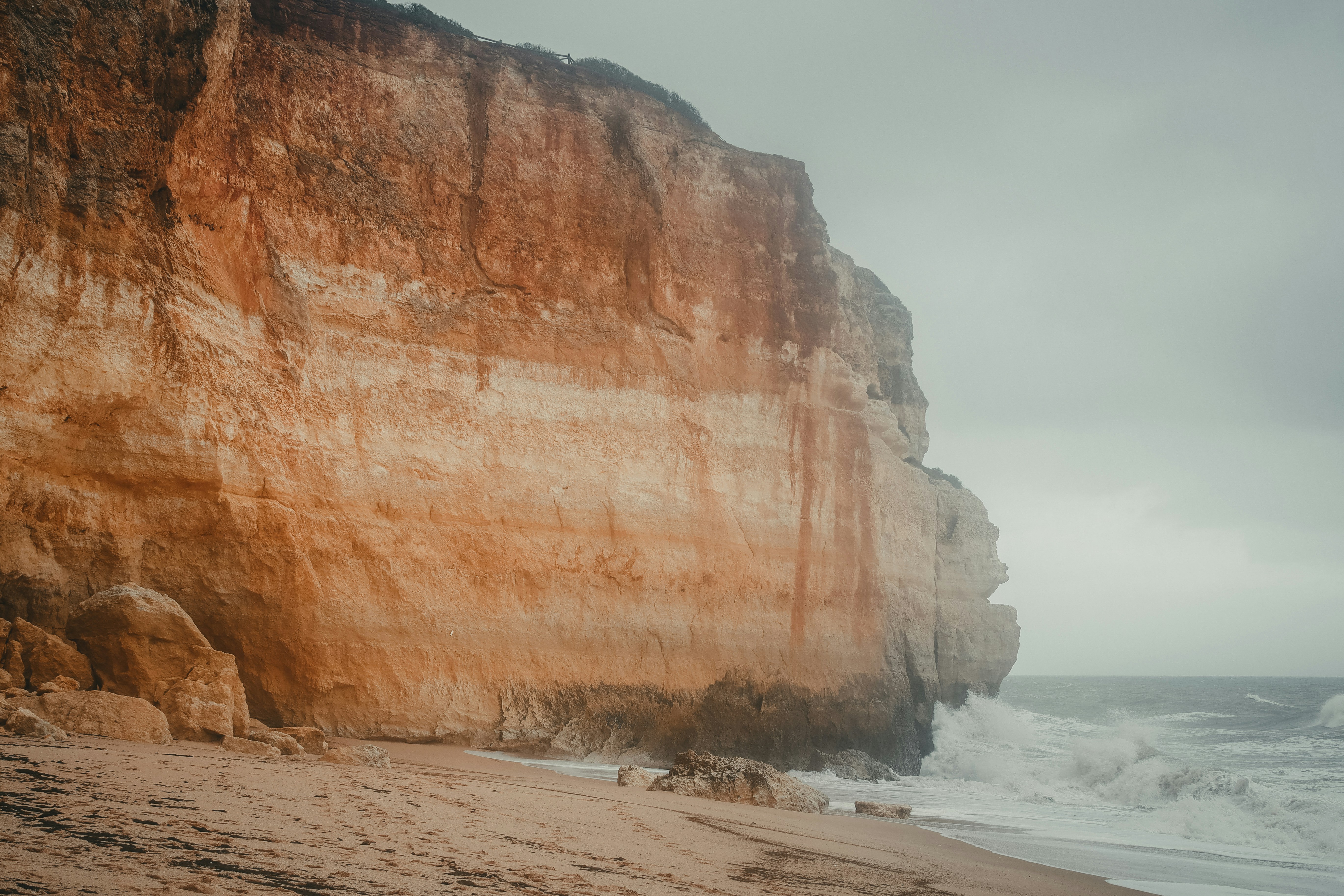 A beach with a large cliff next to the ocean photo – Free Tavira Image ...