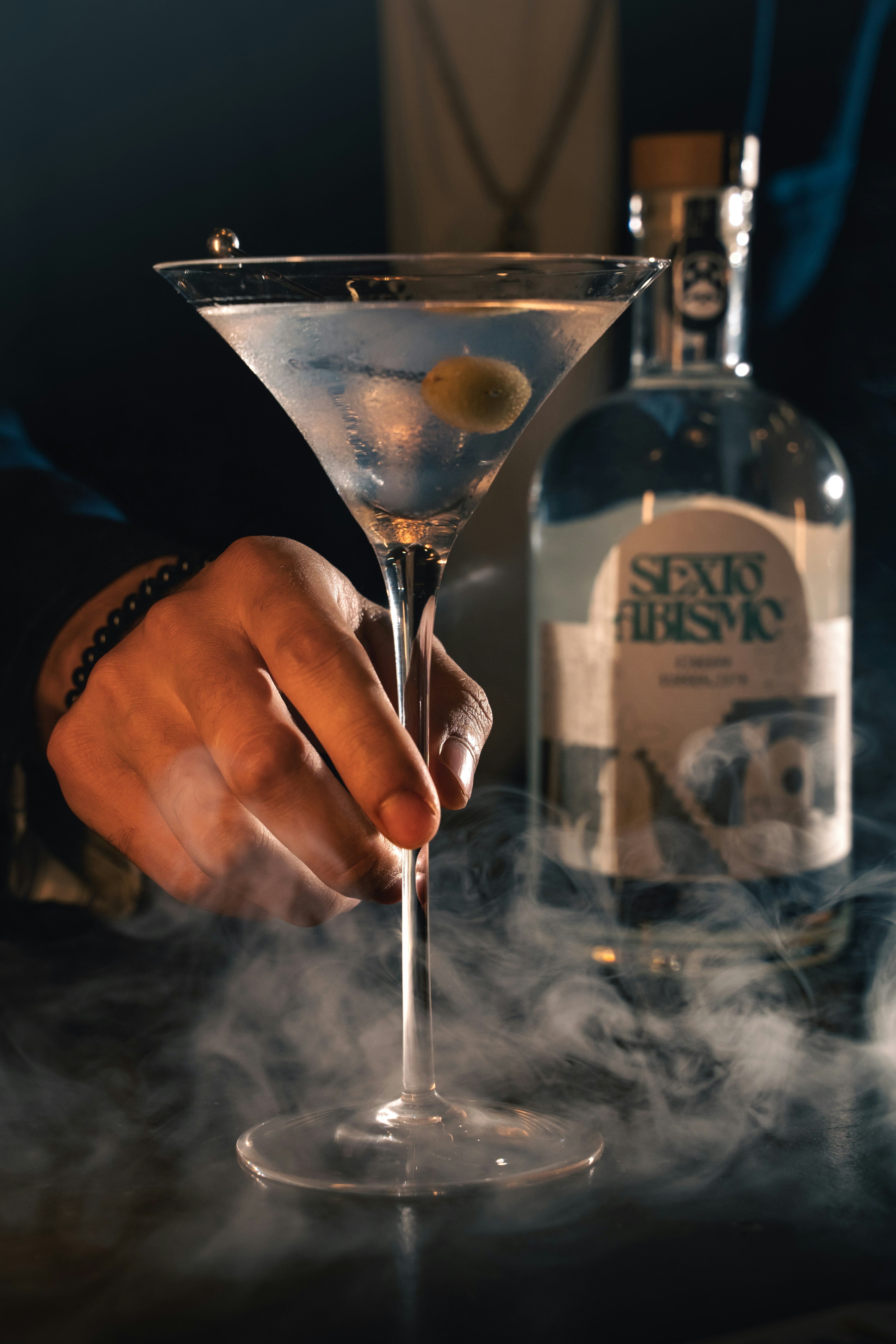 A person holding a martini glass with smoke coming out of it photo ...
