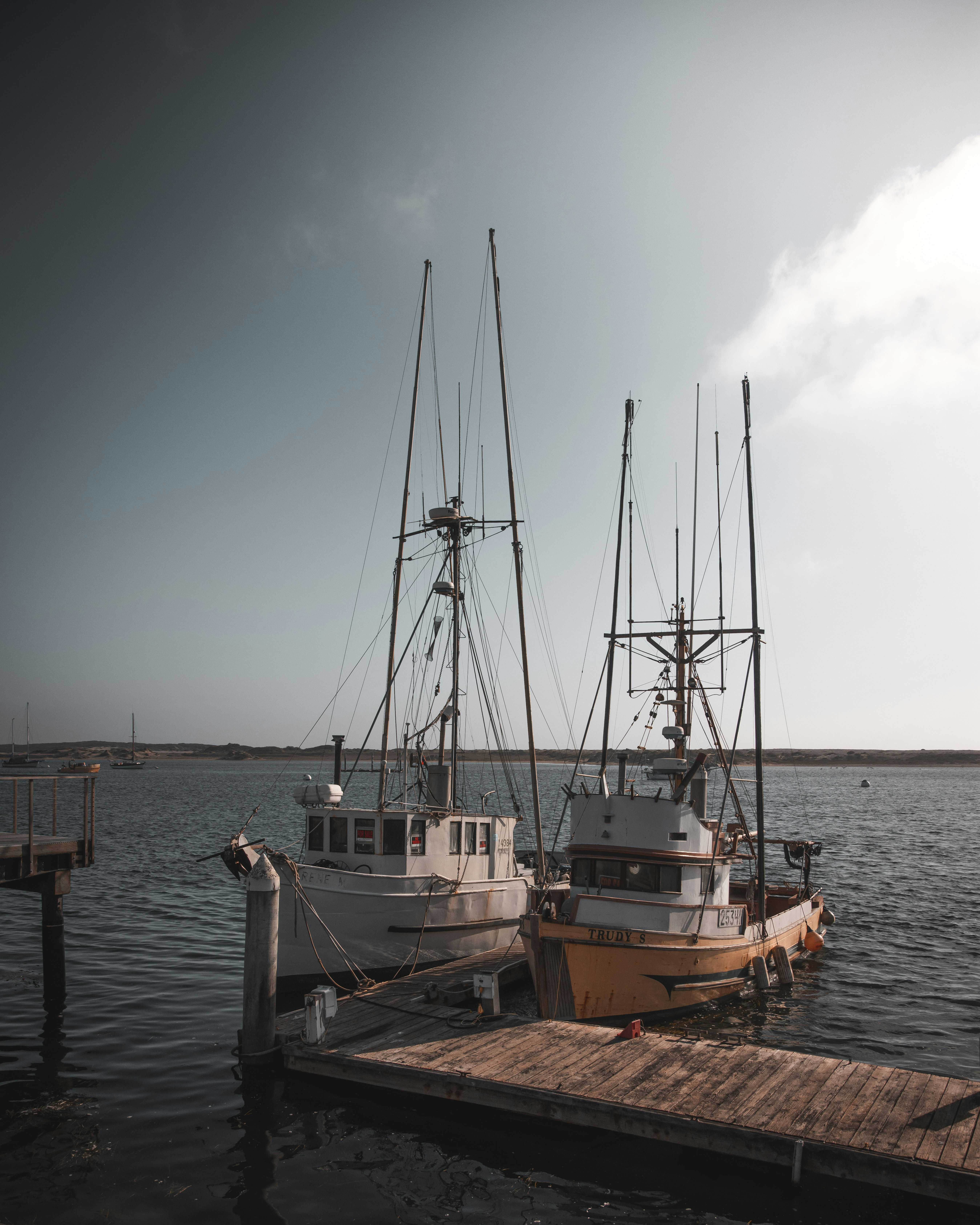 Foto Un par de botes que están sentados en el agua – Imagen Frente al ...