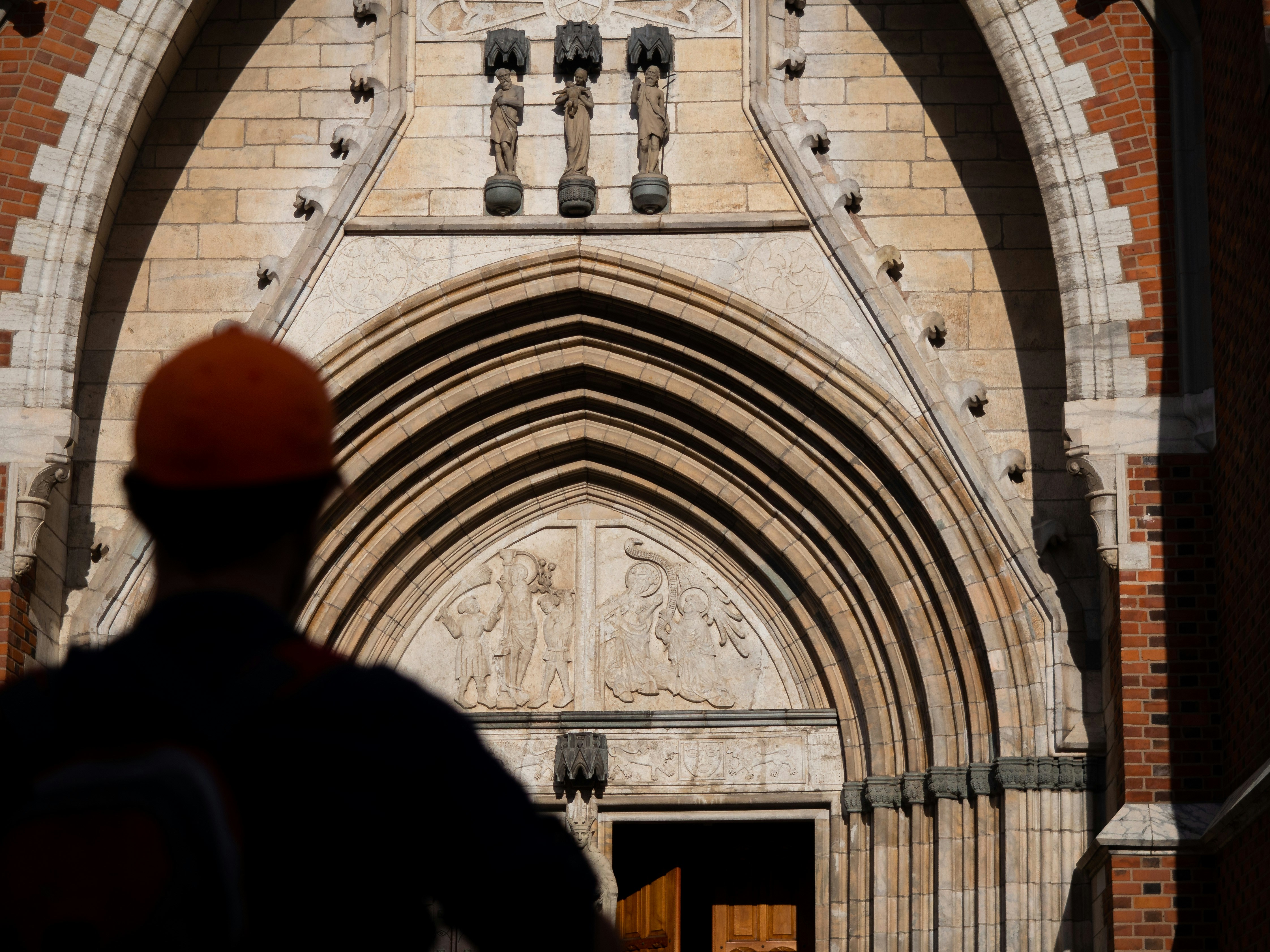 Entering the Arch: A Silhouette Before Sacred Carvings