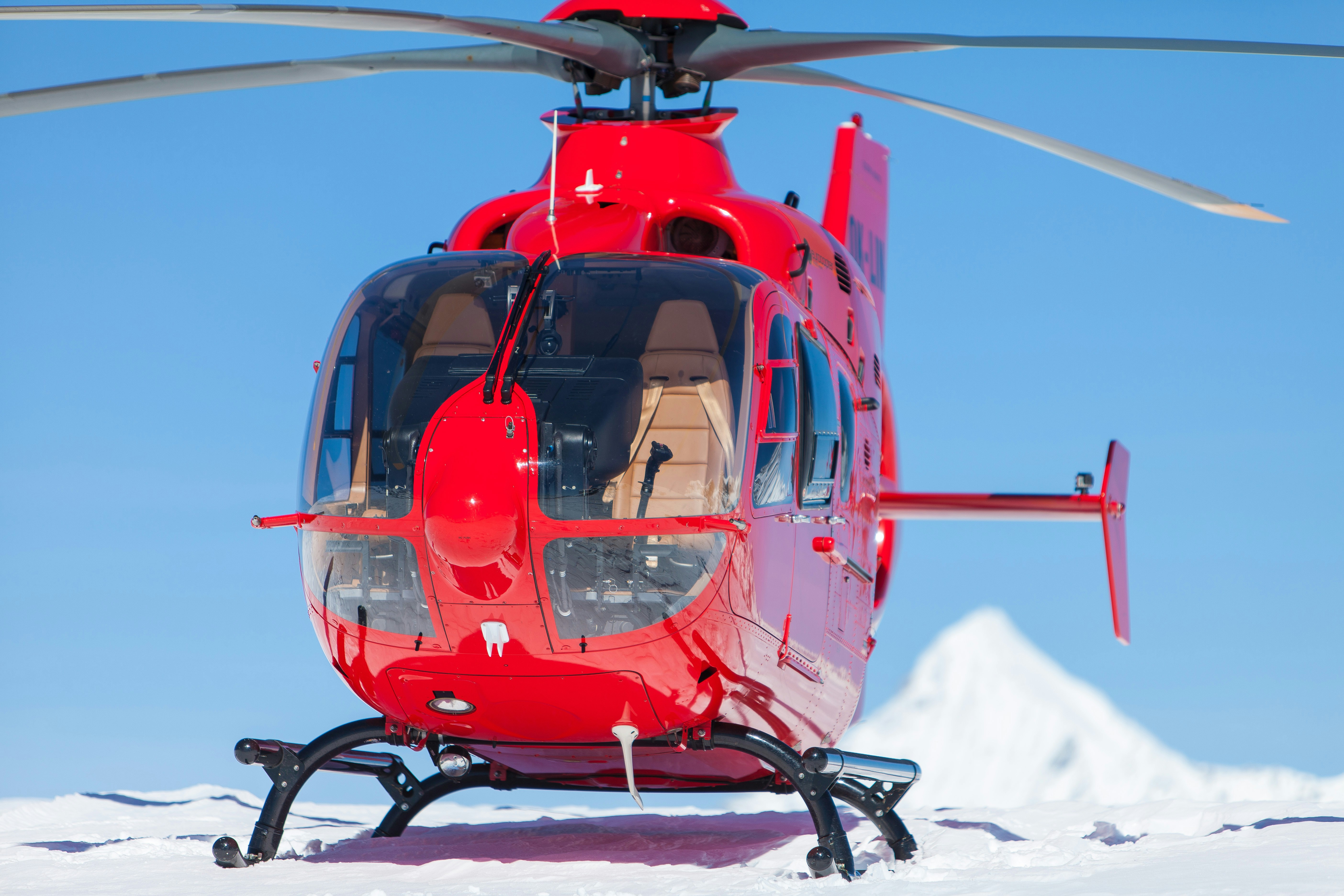 A red helicopter sitting on top of snow covered ground photo – Free ...