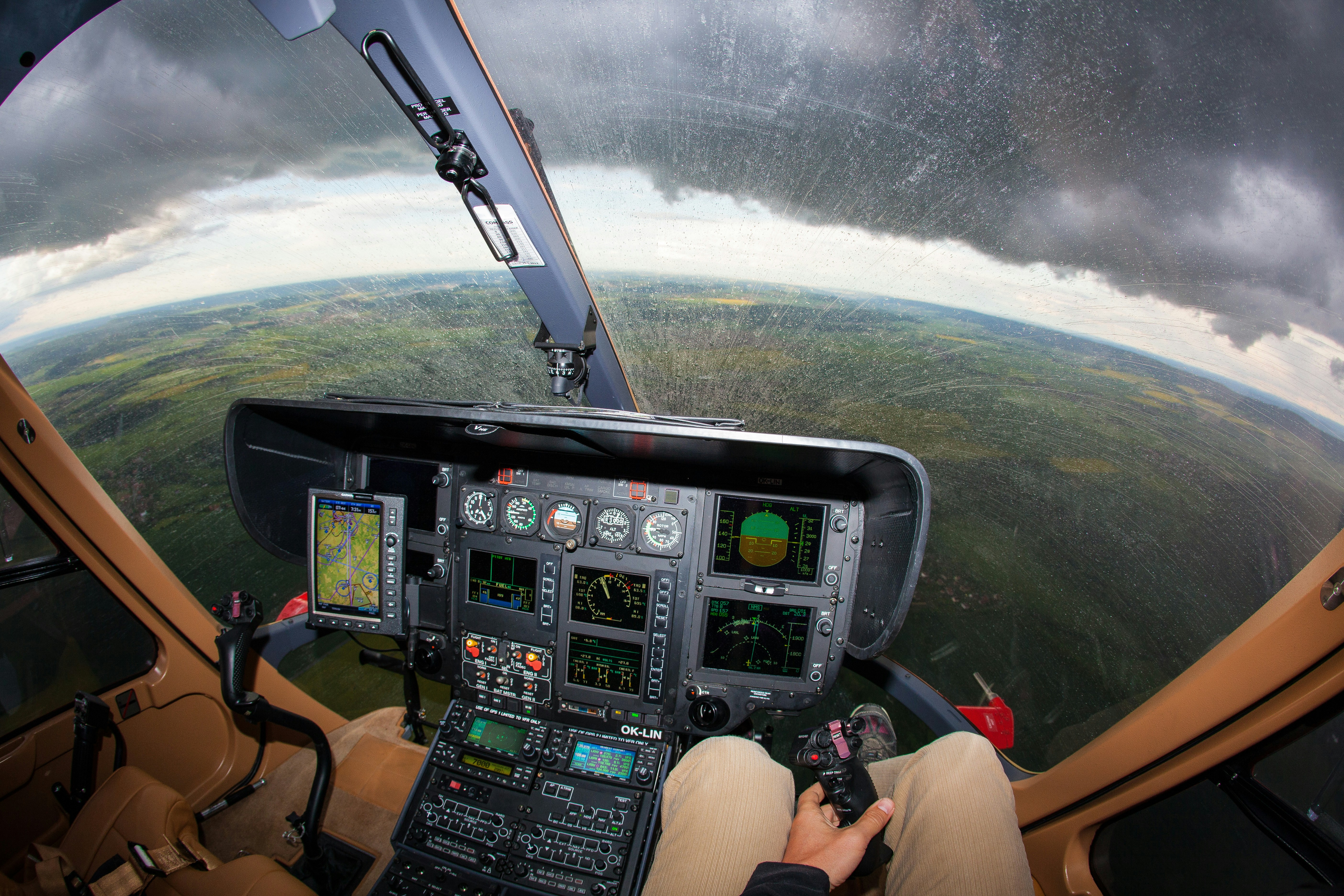 A man flying a plane over a lush green field photo – Free Cockpit Image ...