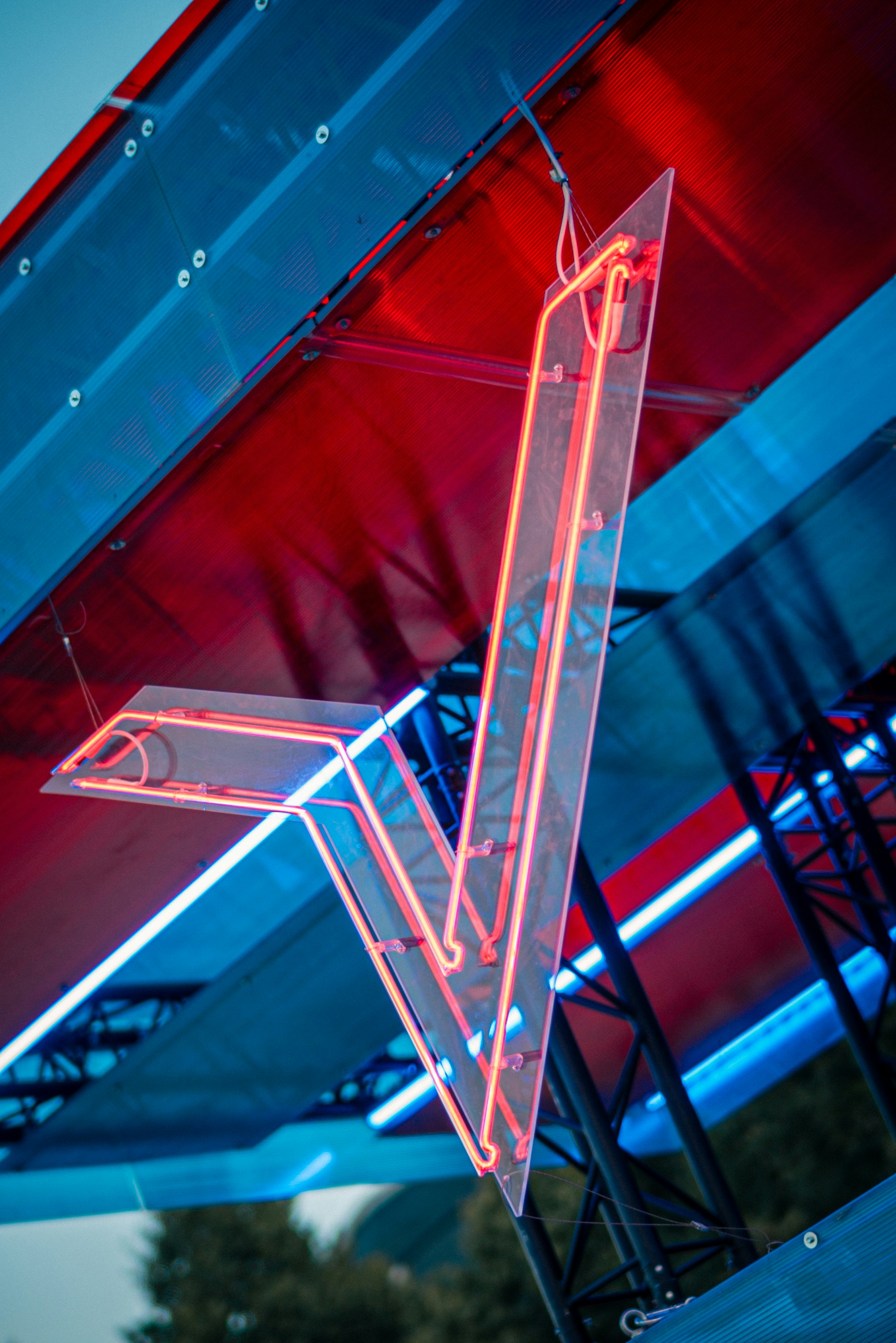 A neon sign hanging from the side of a building photo – Free Image on ...