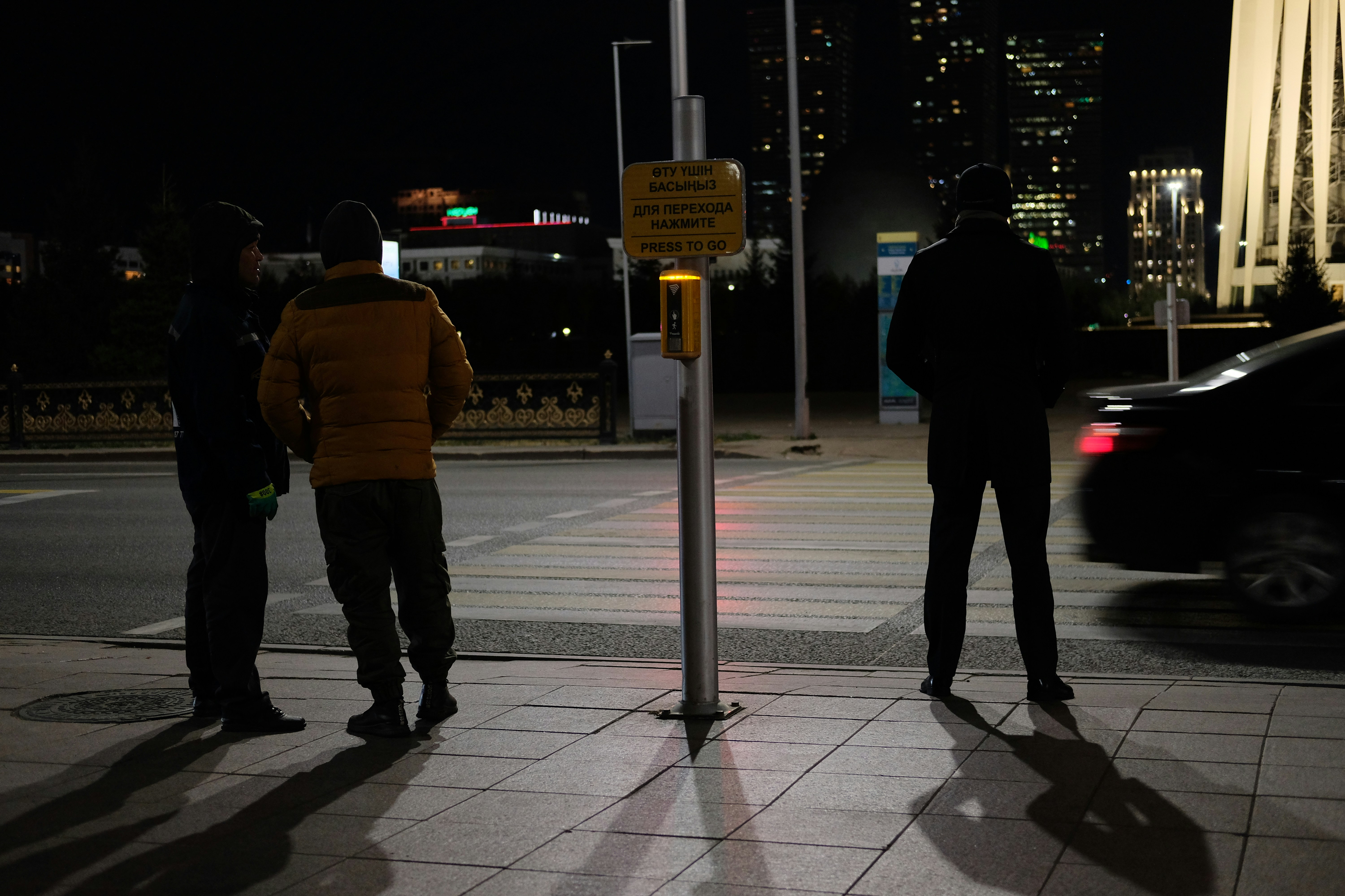 Two men standing next to a street sign at night photo – Free Astana ...
