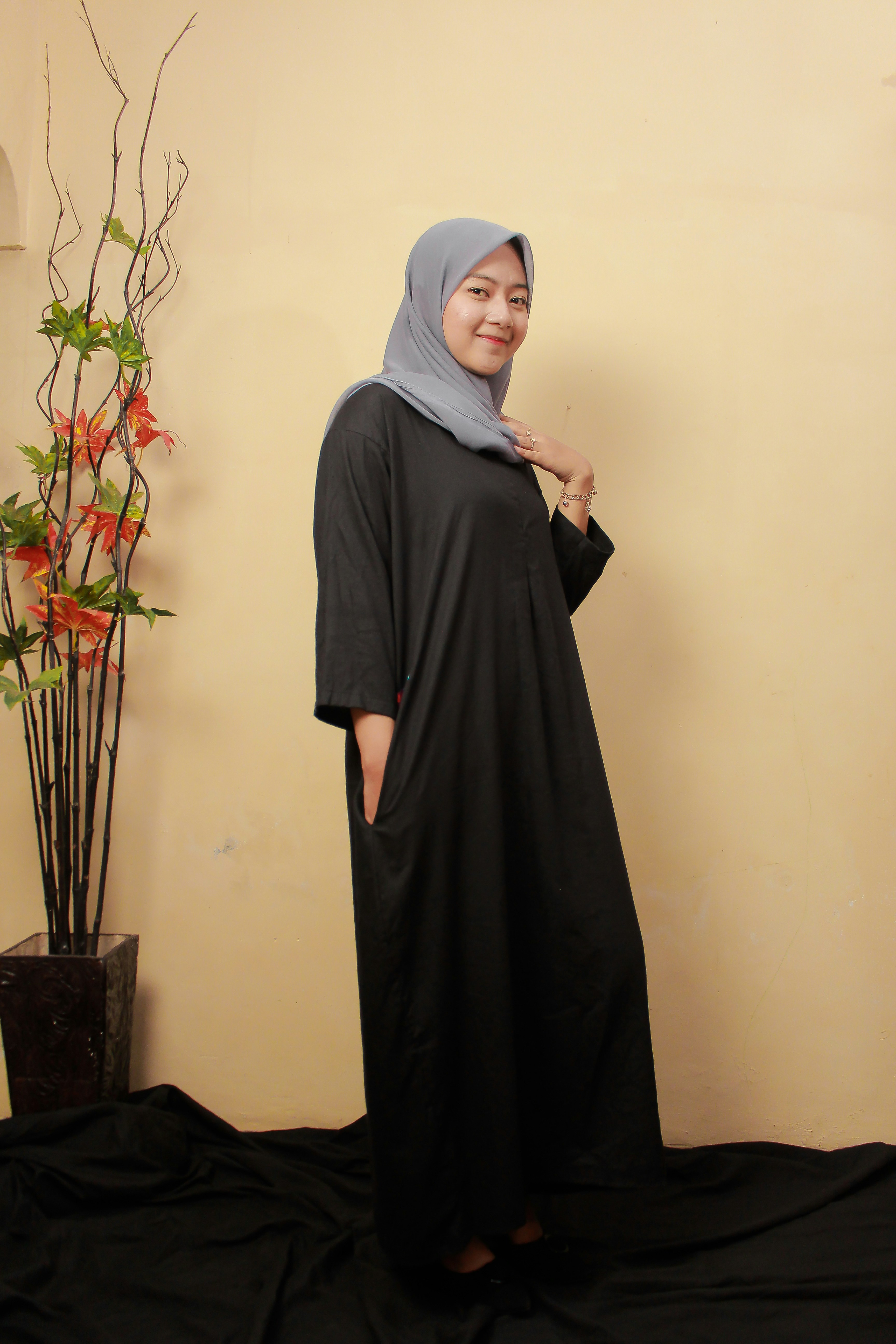 A woman in a hijab standing in front of a plant photo – Free Aesthetic ...