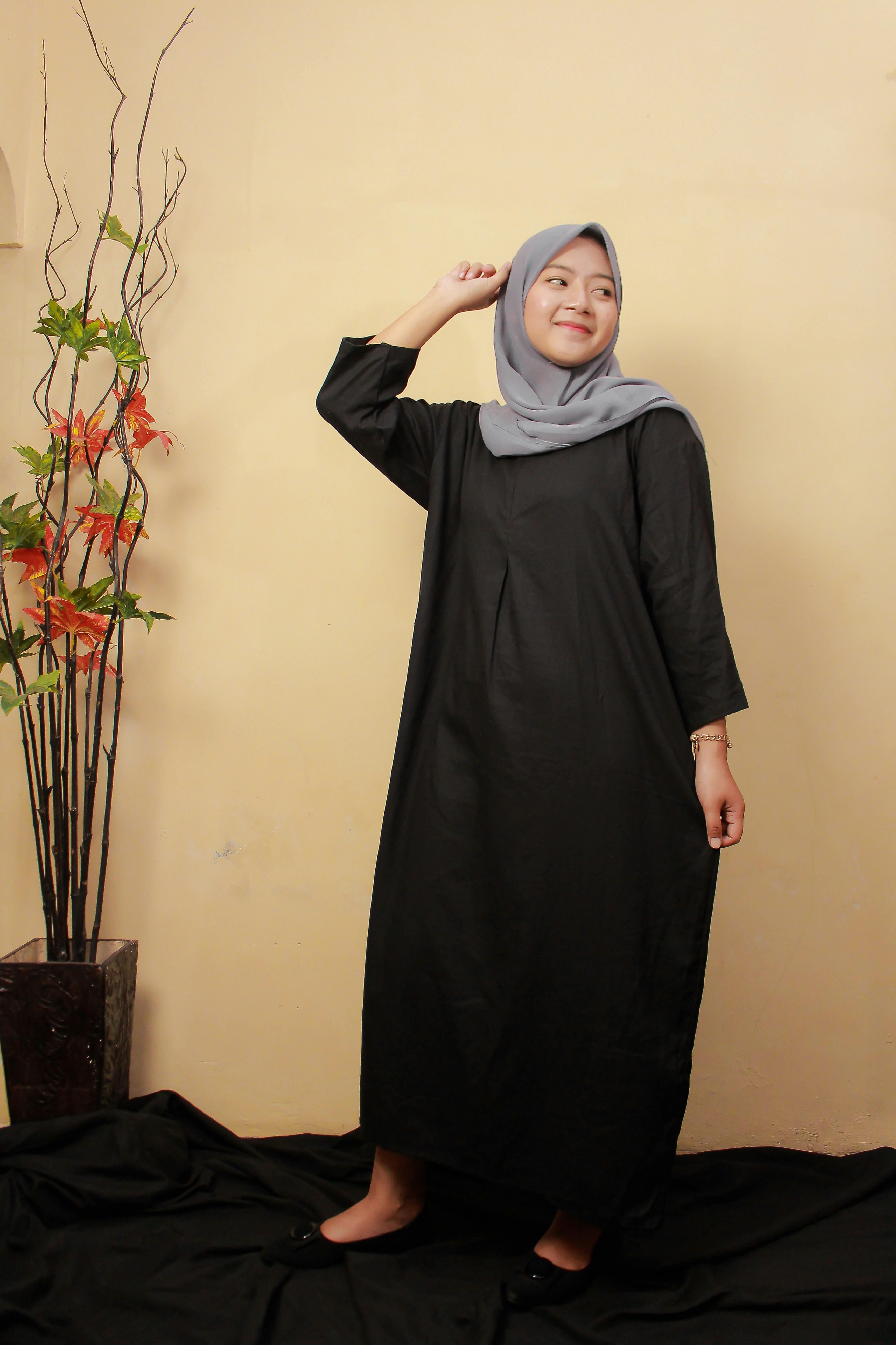 A woman in a black dress standing next to a plant photo – Free ...