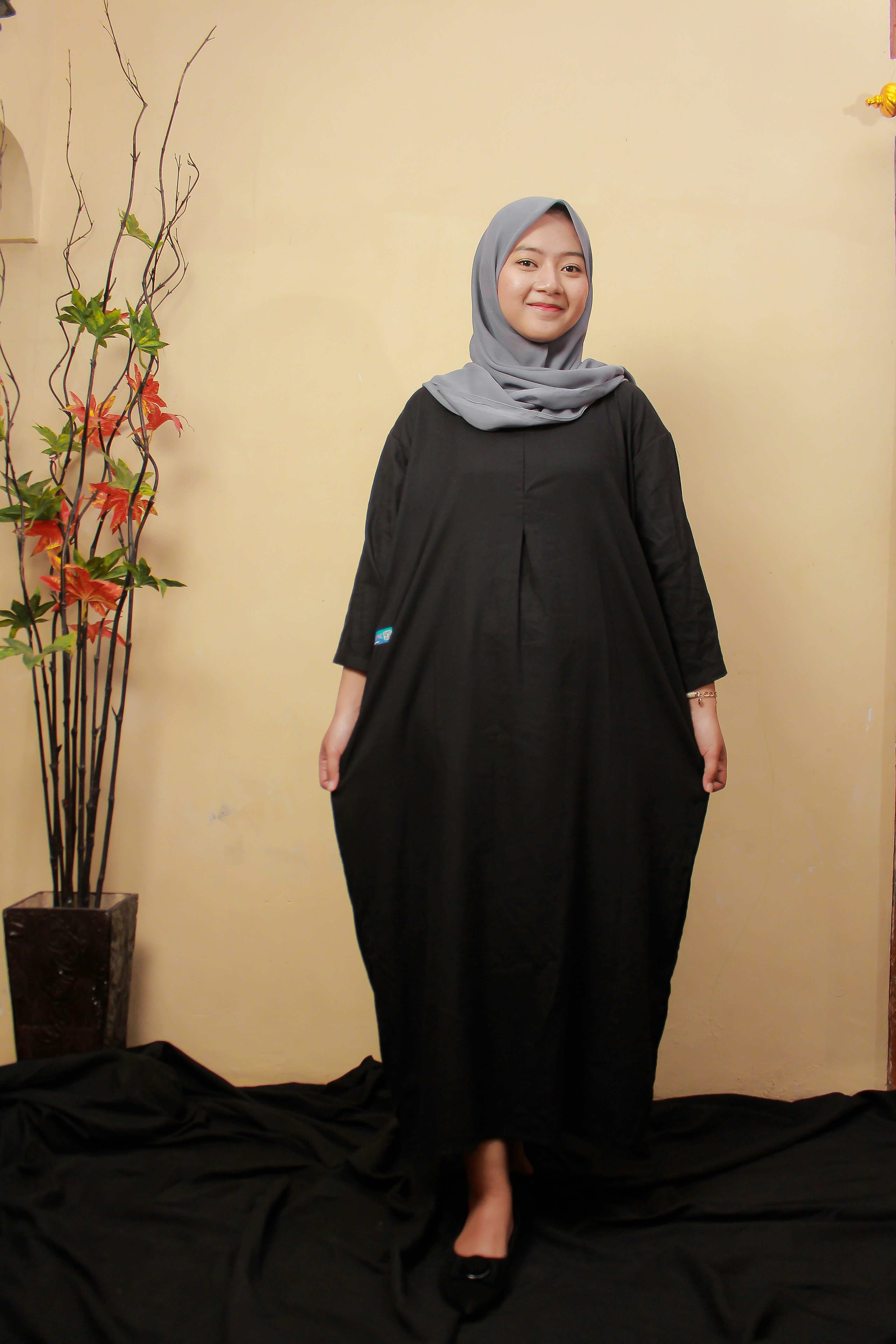 A woman in a black dress standing in front of a plant photo – Free ...