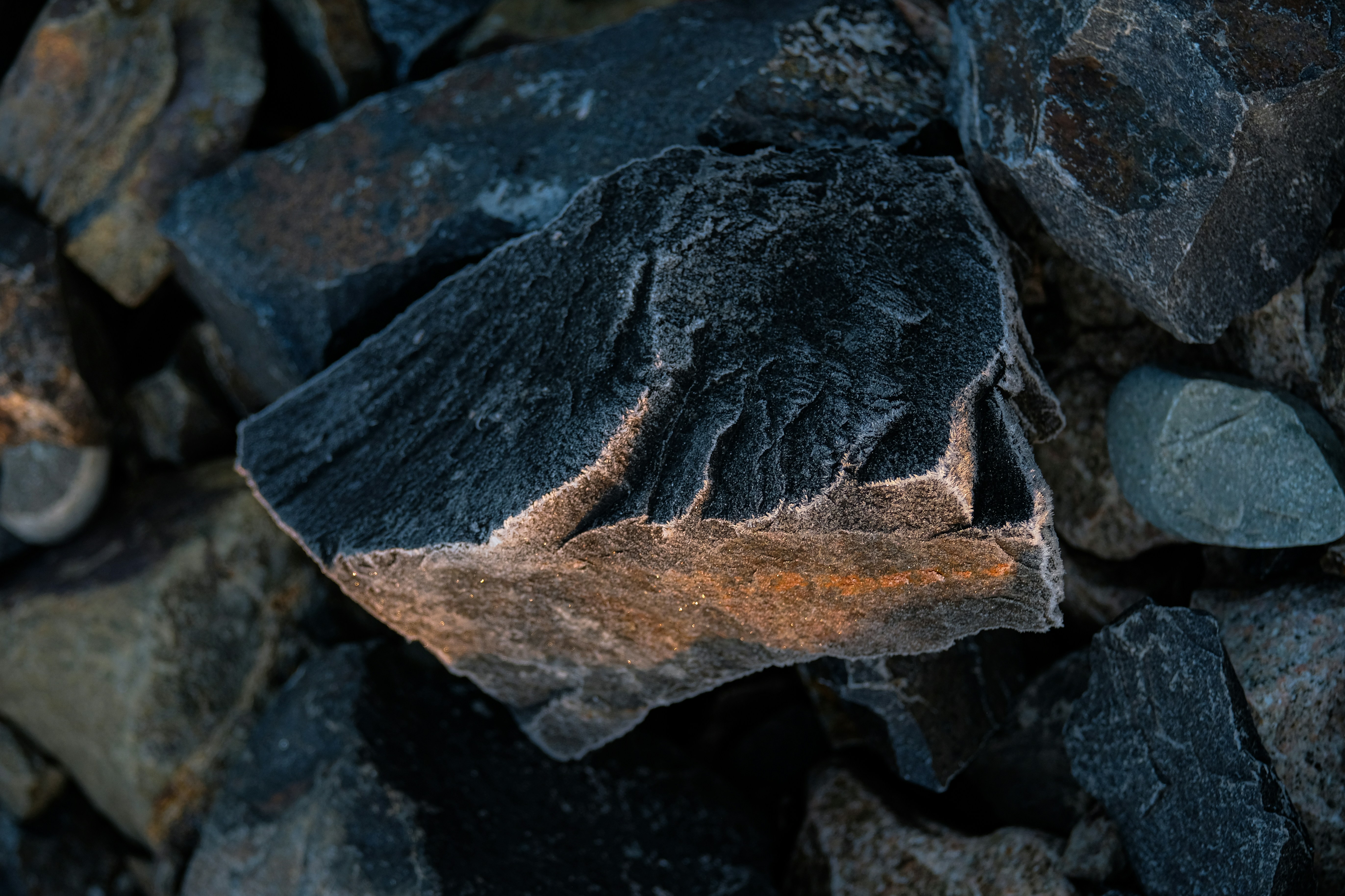 A pile of black rocks with a light shining on them photo – Free Rock ...