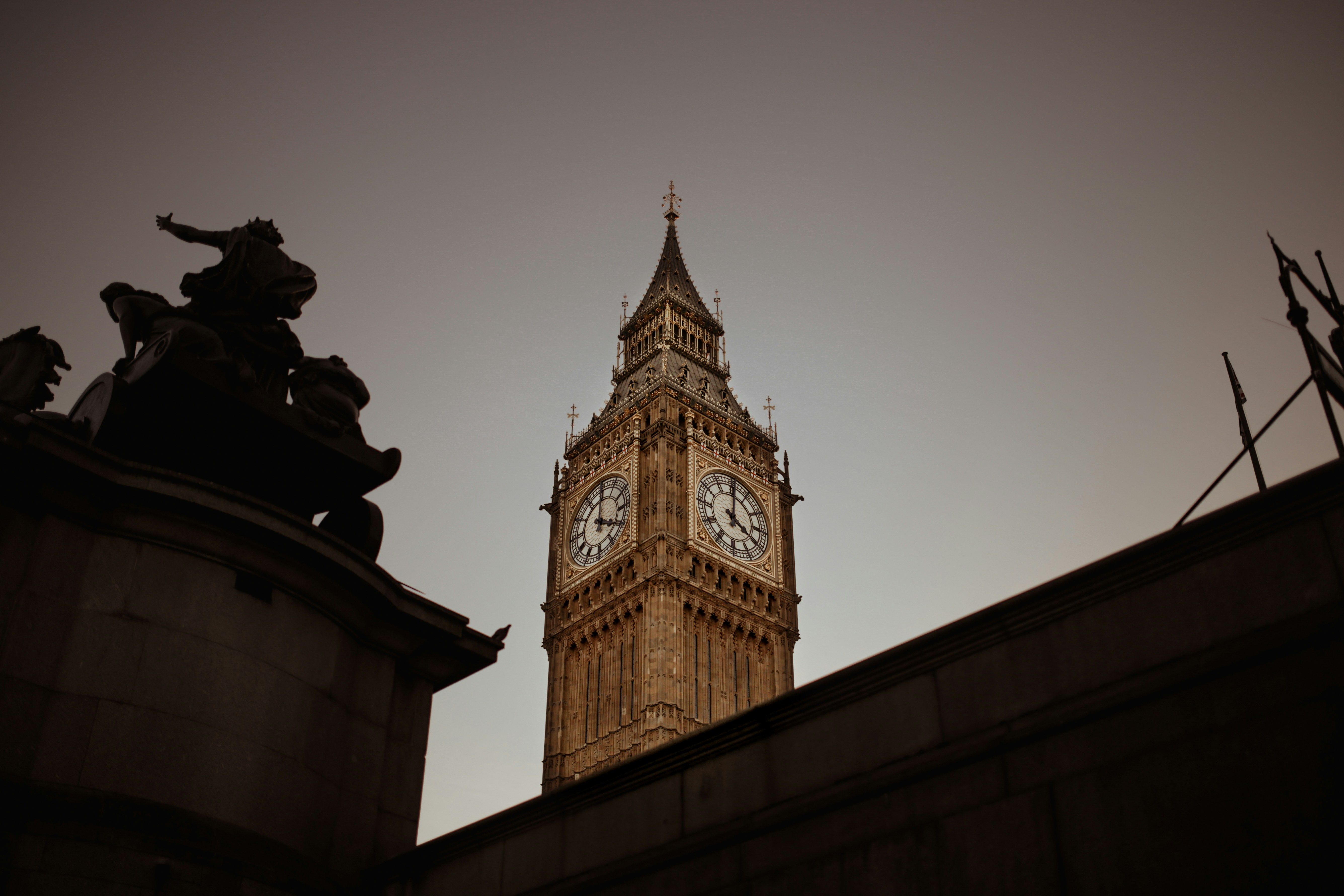 Amber silhouettes: Big Ben rises over a shadowed railing at dusk