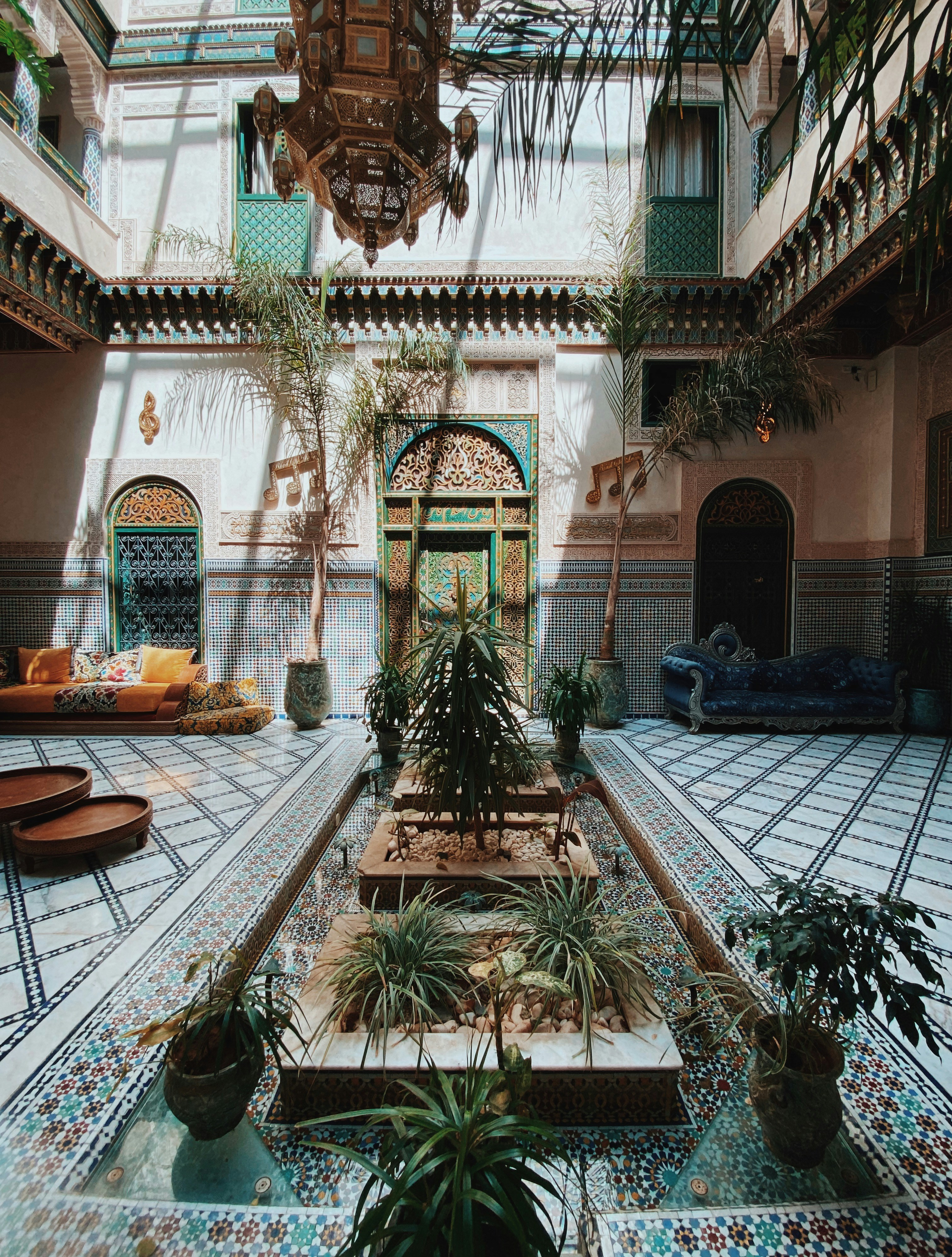 A courtyard with a fountain surrounded by potted plants photo – Free ...