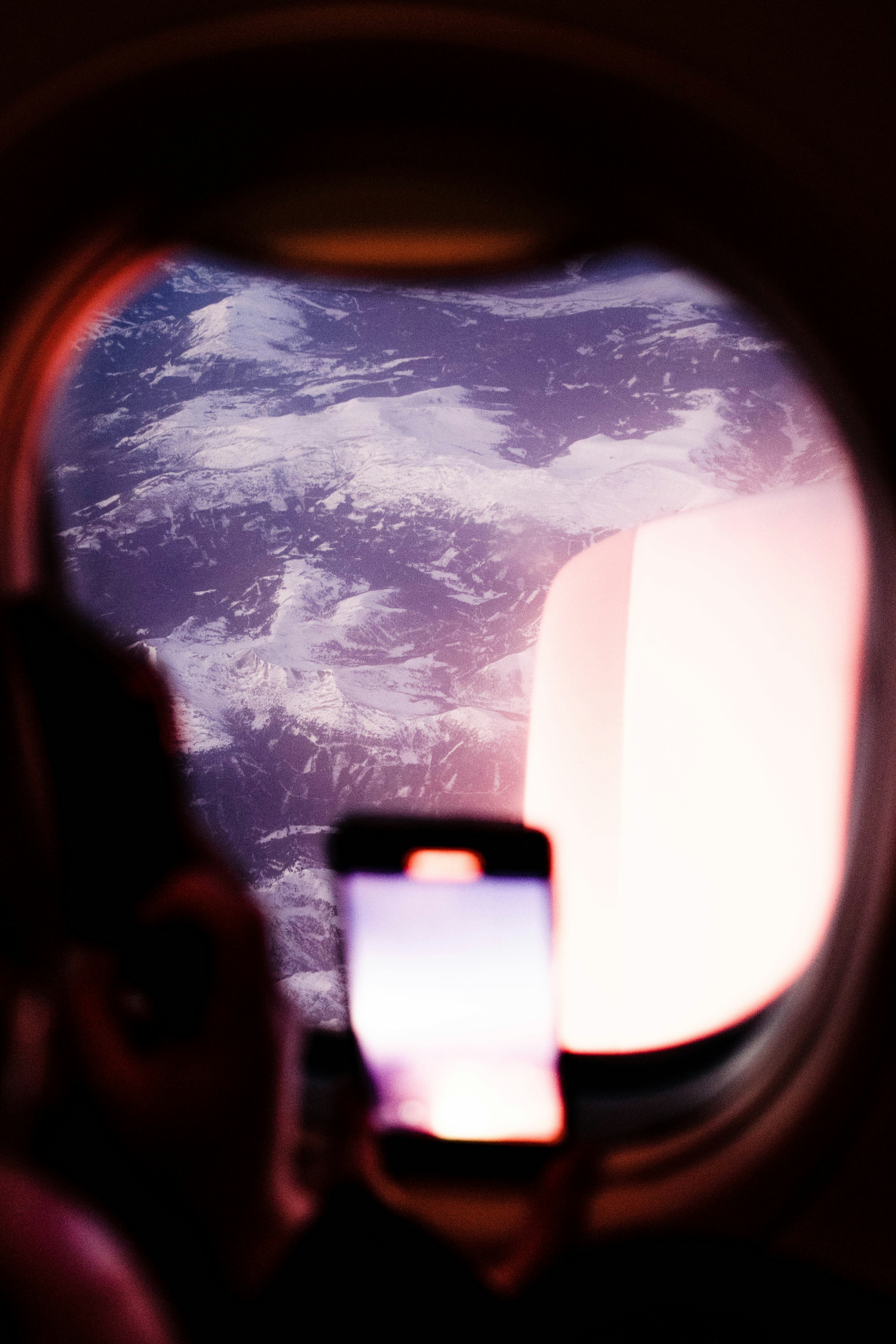 Glacial Vista through the Oval Window: Snowy Peaks from a Passenger's Seat