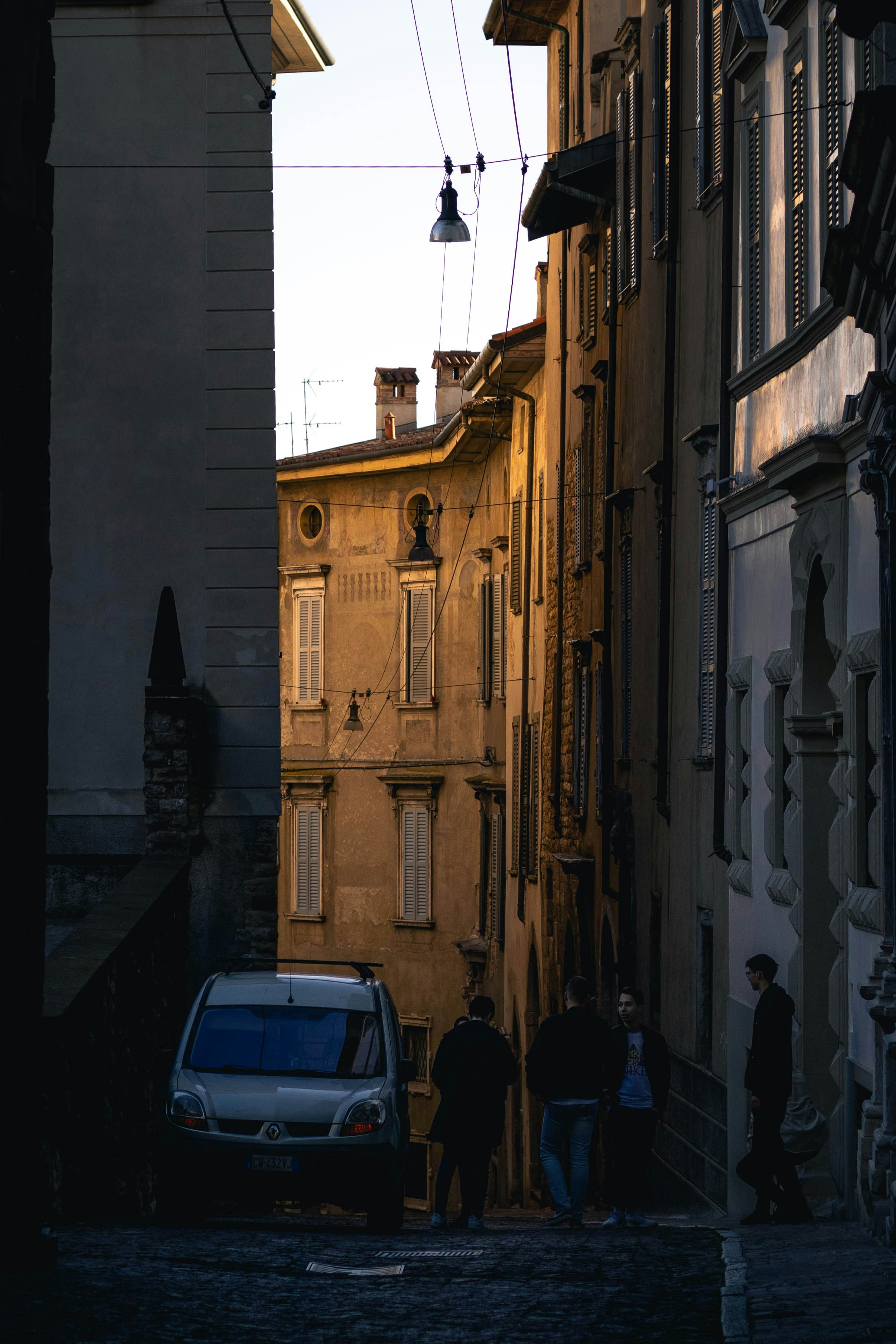 a car parked on the side of a street next to tall buildings