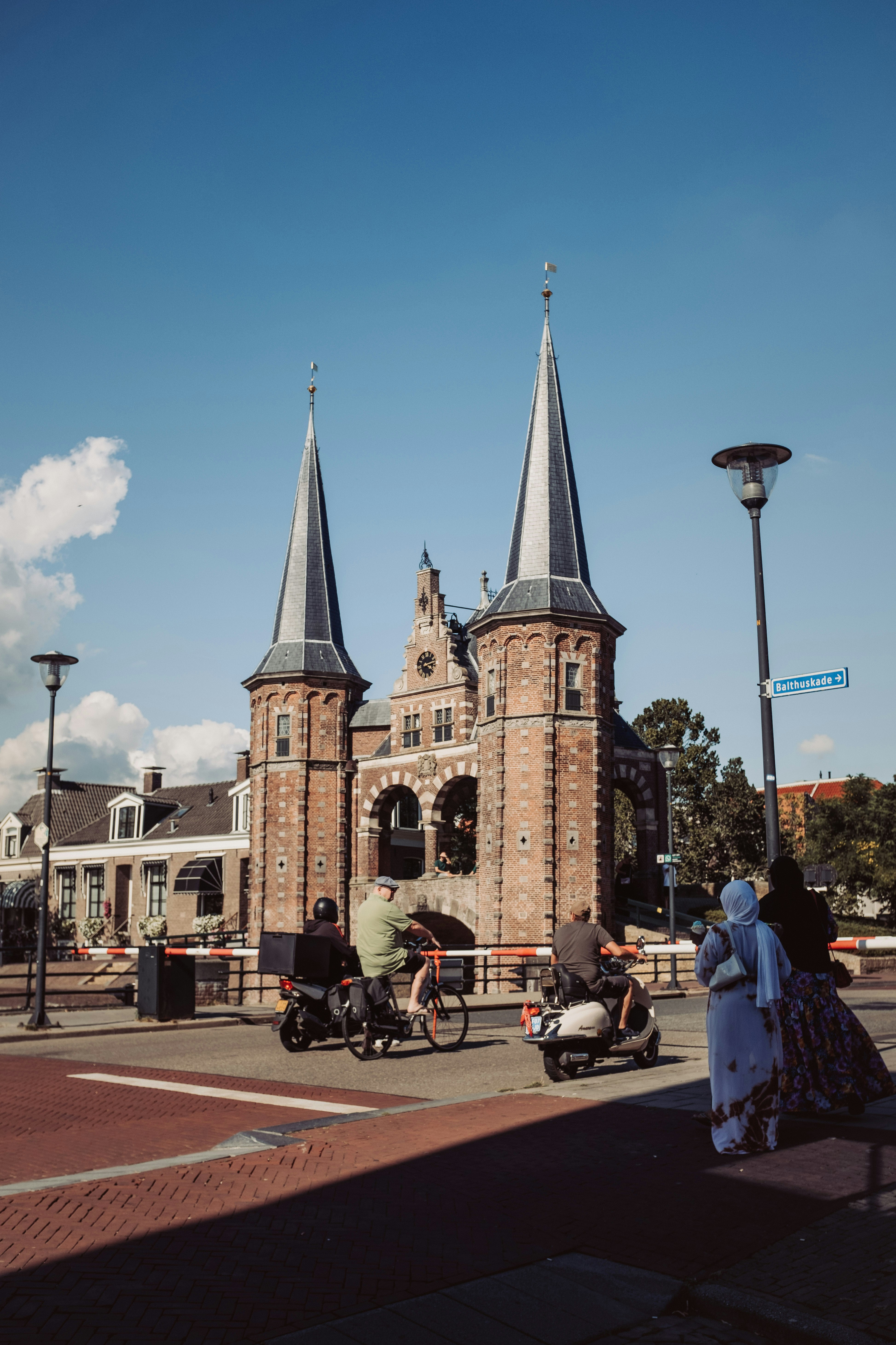 Red-brick Gatehouse Framed by Twin Spires Under a Clear Blue Sky