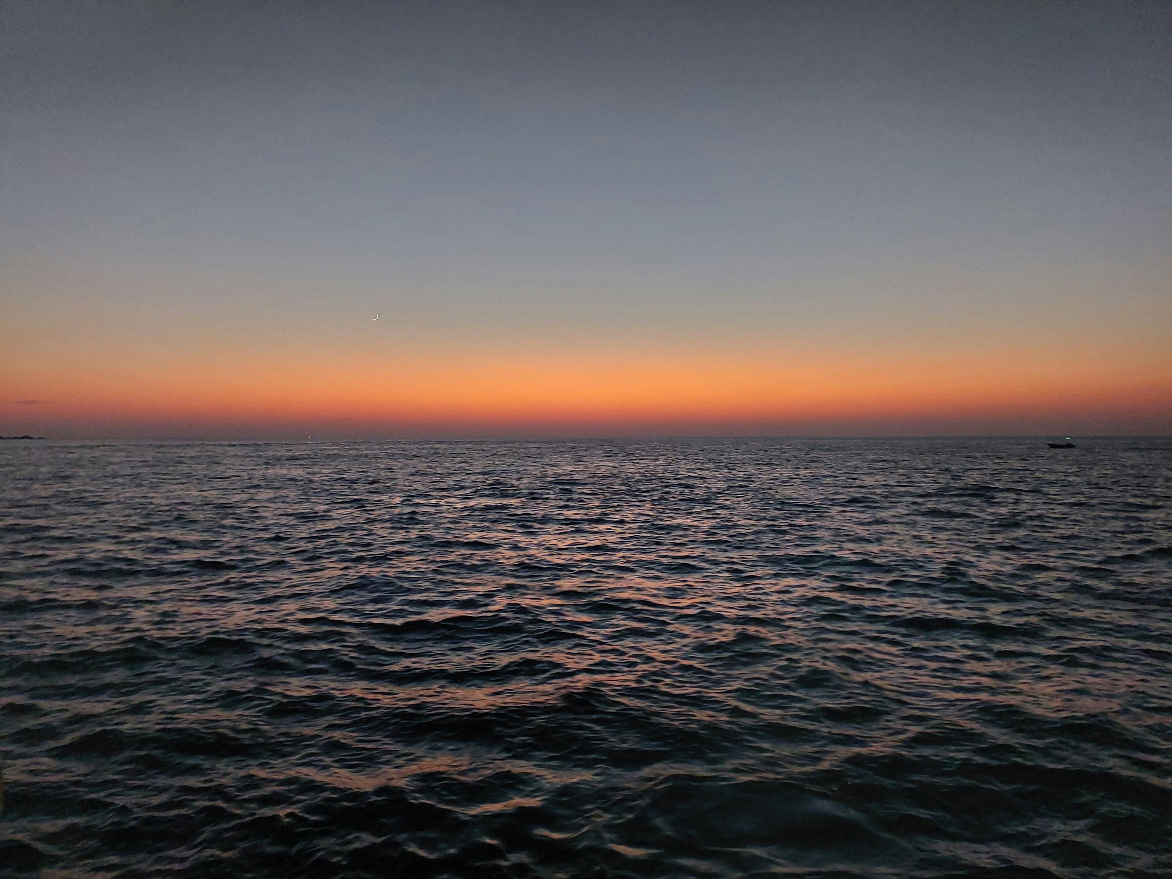 Calm ocean waves under a gradient sunset sky.