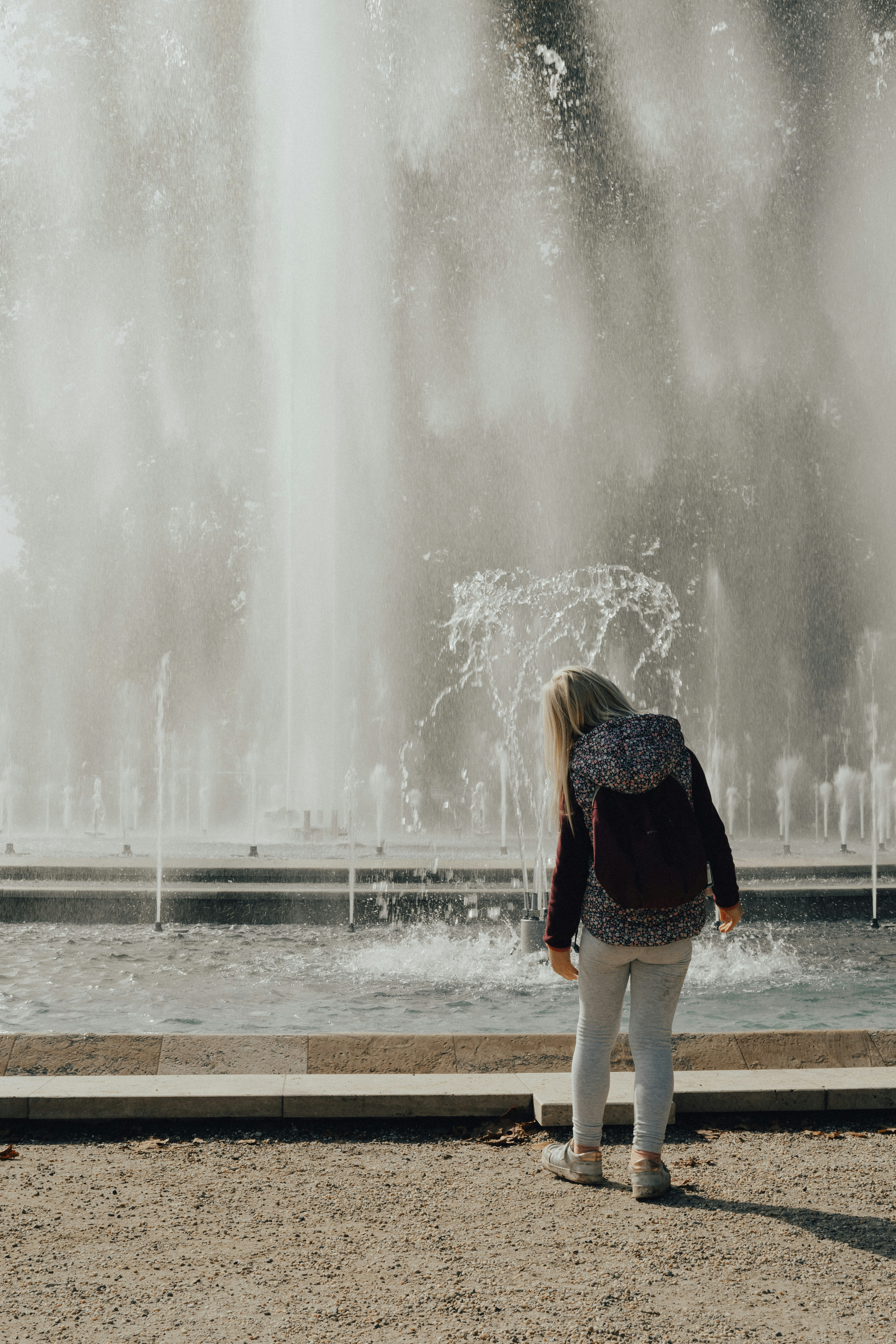 Mist at Her Back: Quiet Moment by the Fountain