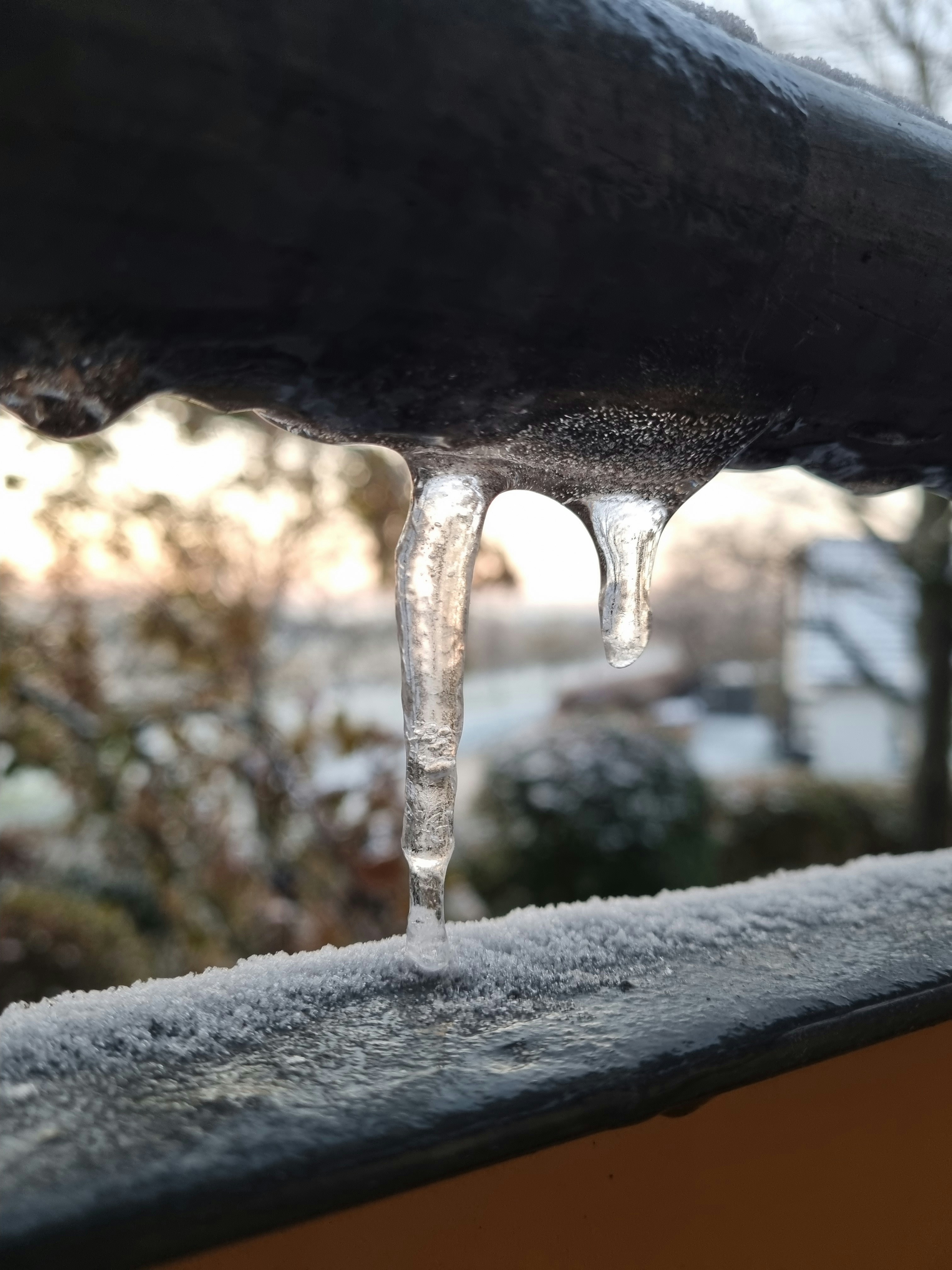 Icicle Sculptures Drip Over a Frosted Balcony Rail at Dawn