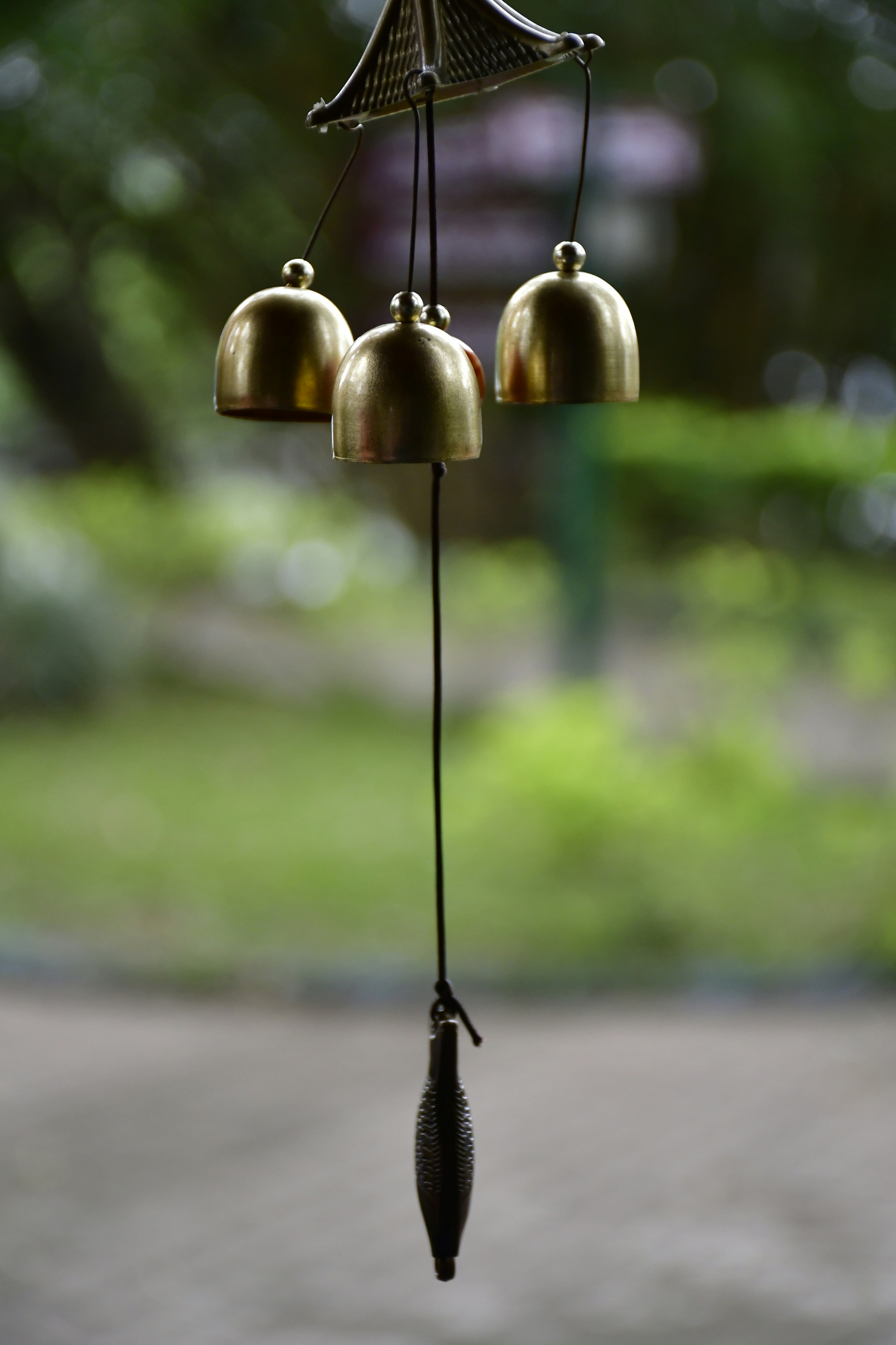 a metal bell with three bells hanging from it
