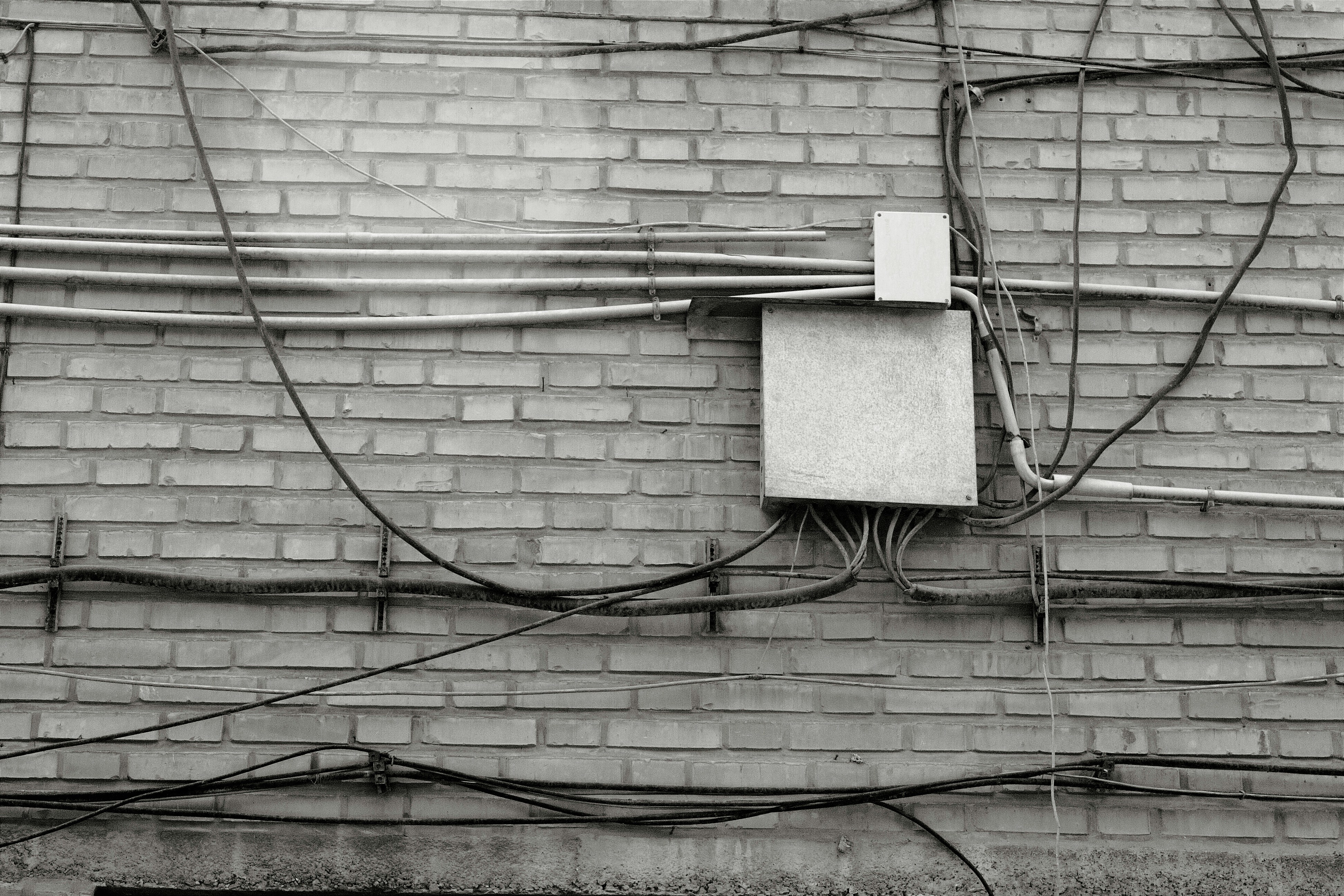 A black and white photo of an electrical box on a brick wall photo ...