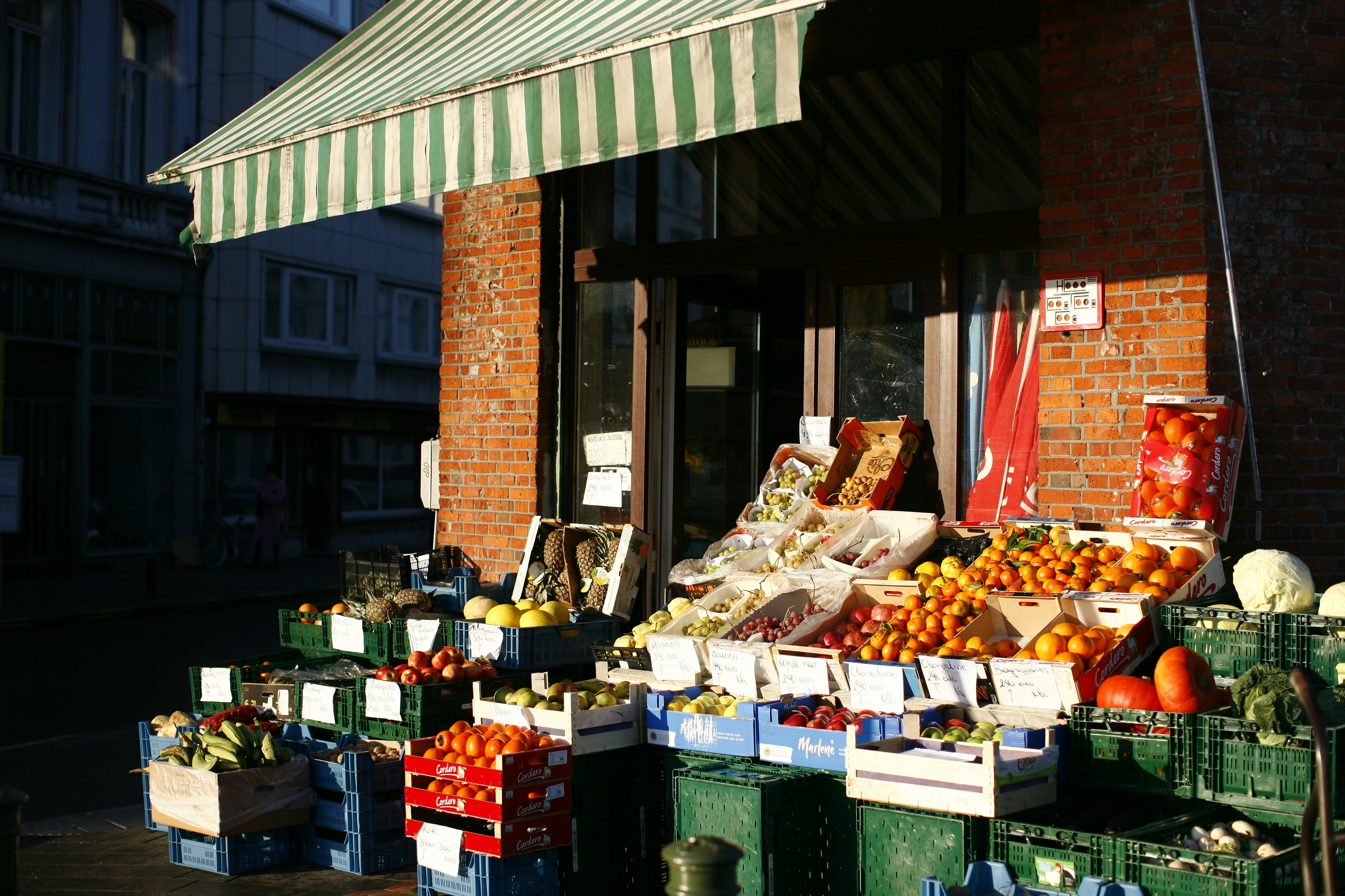 A fruit stand in front of a brick building photo – Free Gent Image on ...