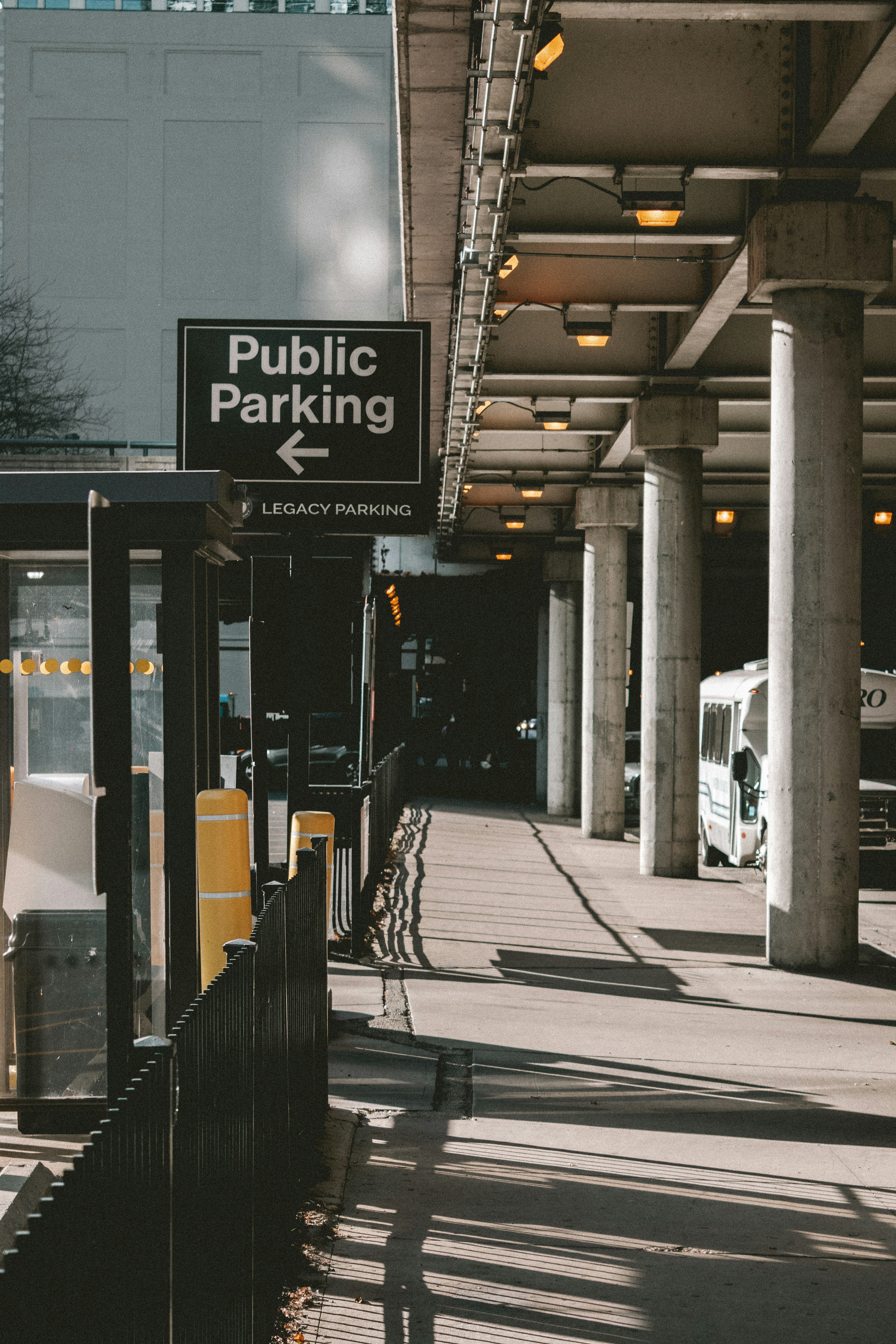 Public Parking Corridor: Lines, Shadows, and a Signpost Away