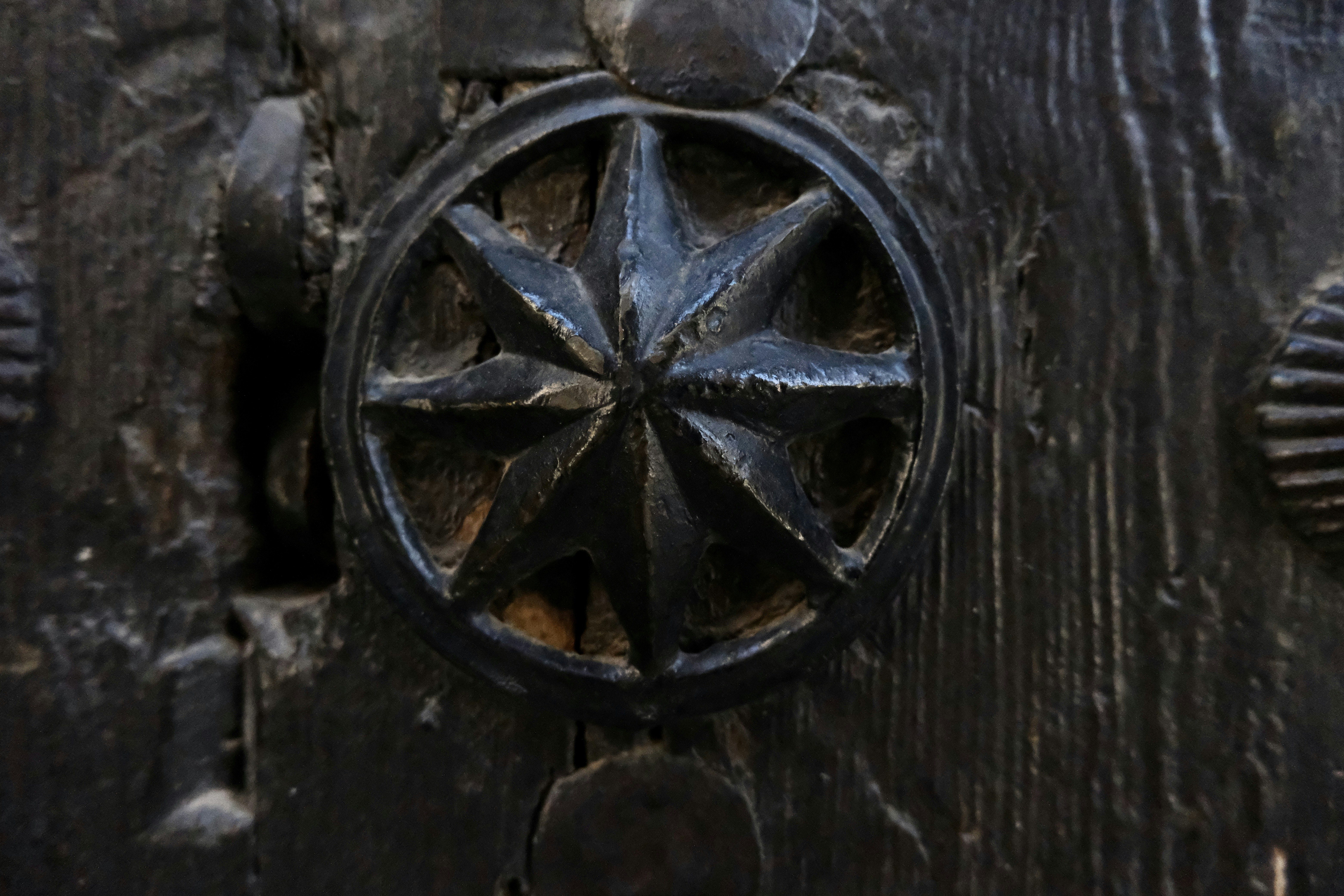 Ornate star emblem carved into an aged wooden door.