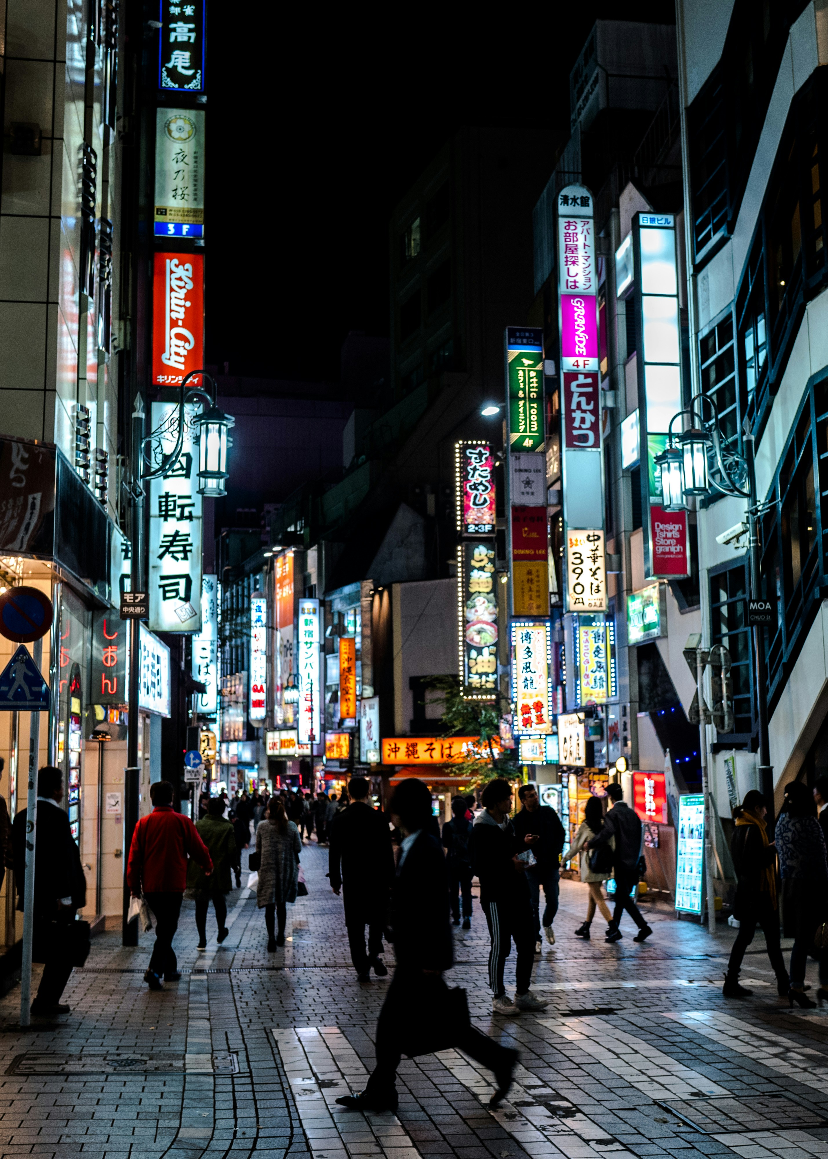 A crowded city street at night with people walking around photo – Free ...
