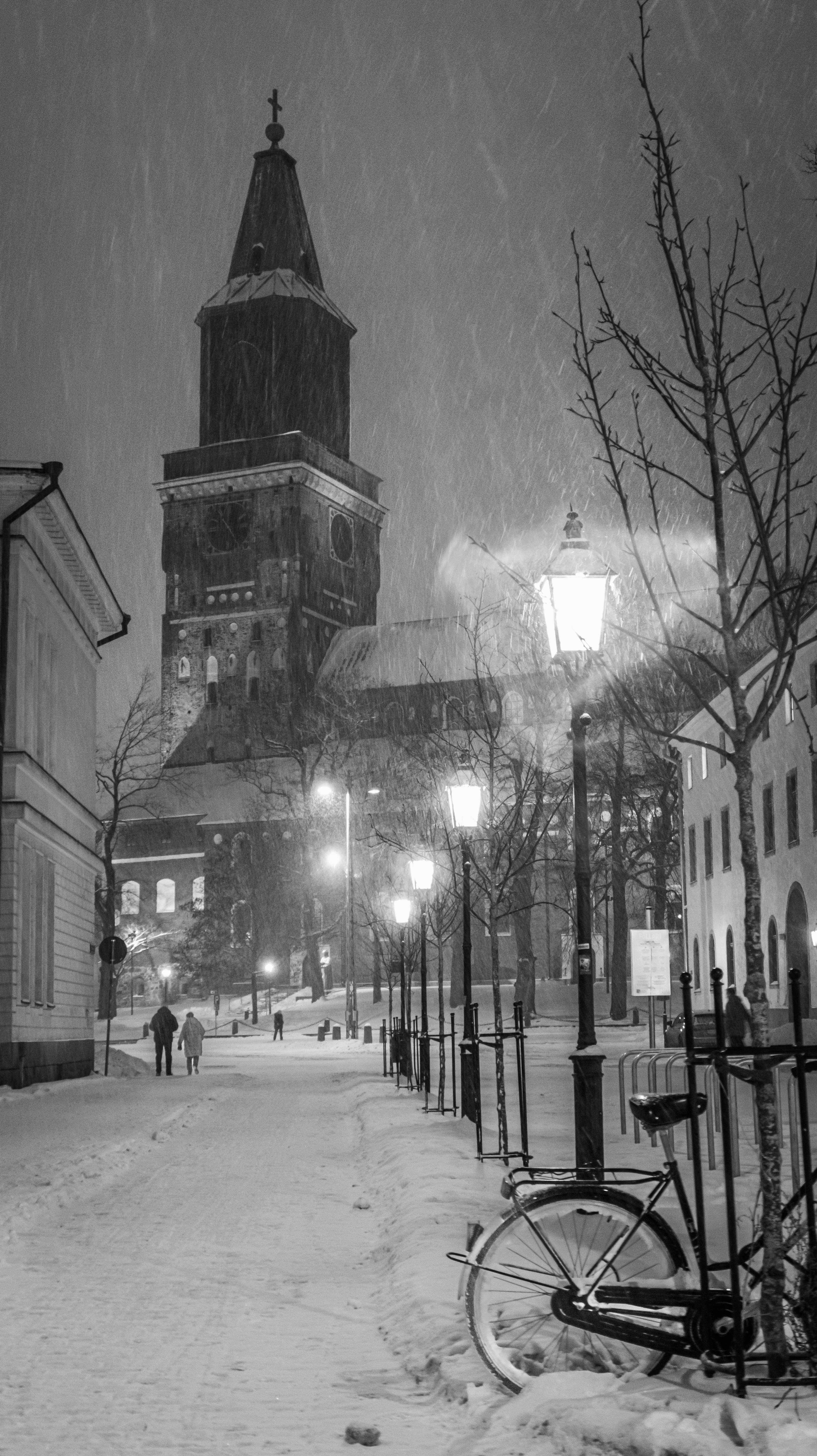 a black and white photo of a snowy street
