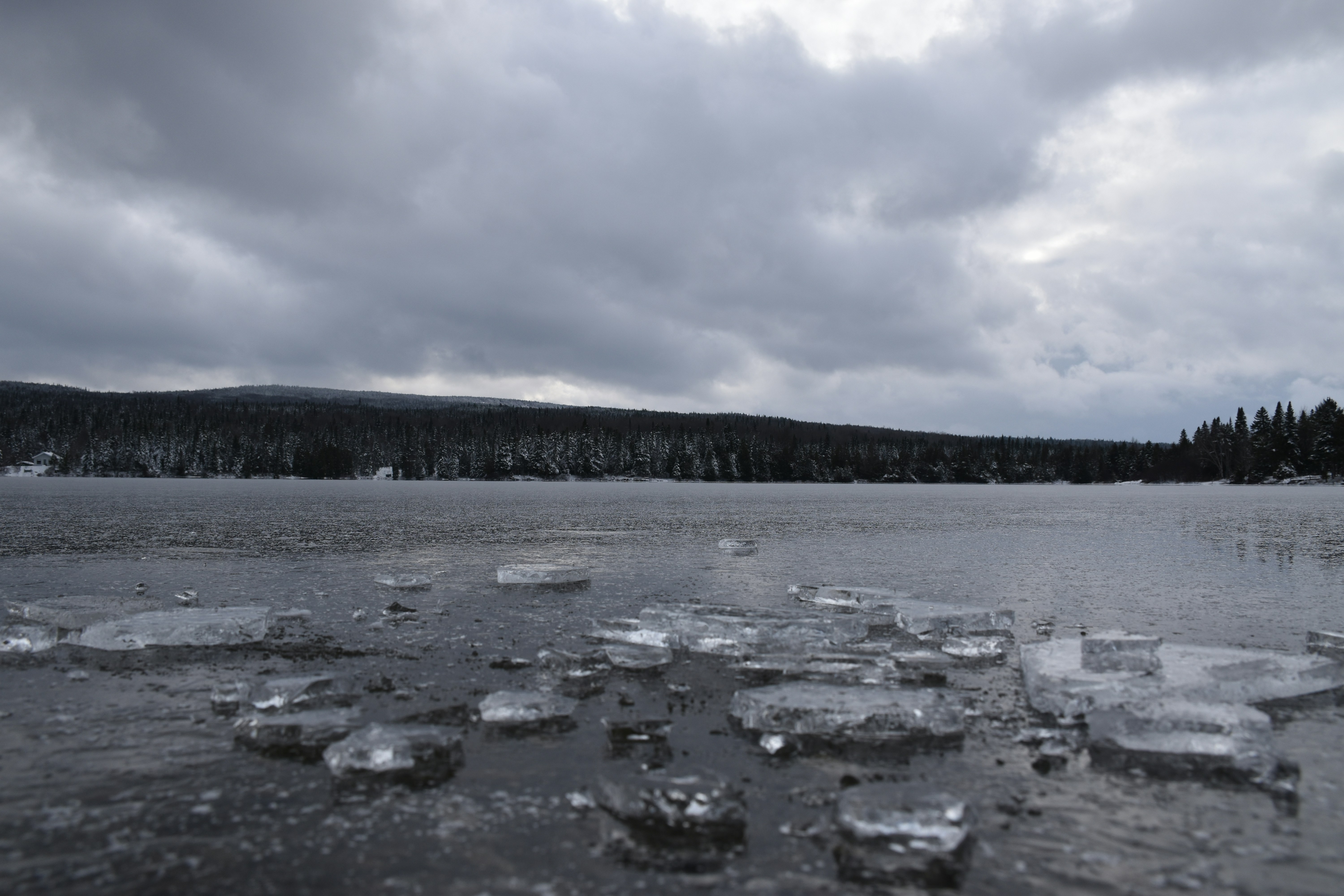 Crystalline Edge: Ice Fragments on a Frozen Lake Beneath a Clouded Sky