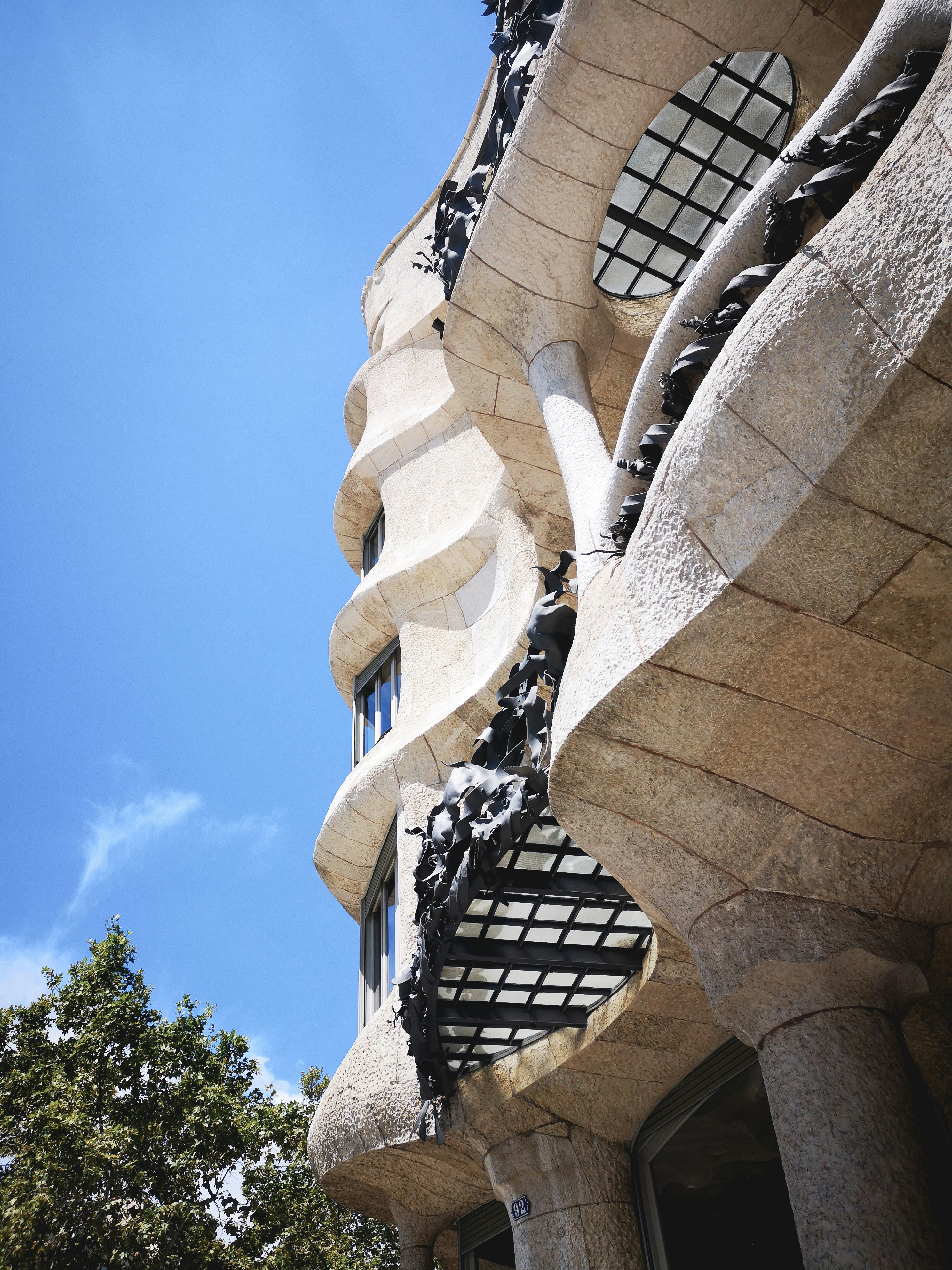 Curved Facade Cadence: Stone Waves Against a Clear Sky