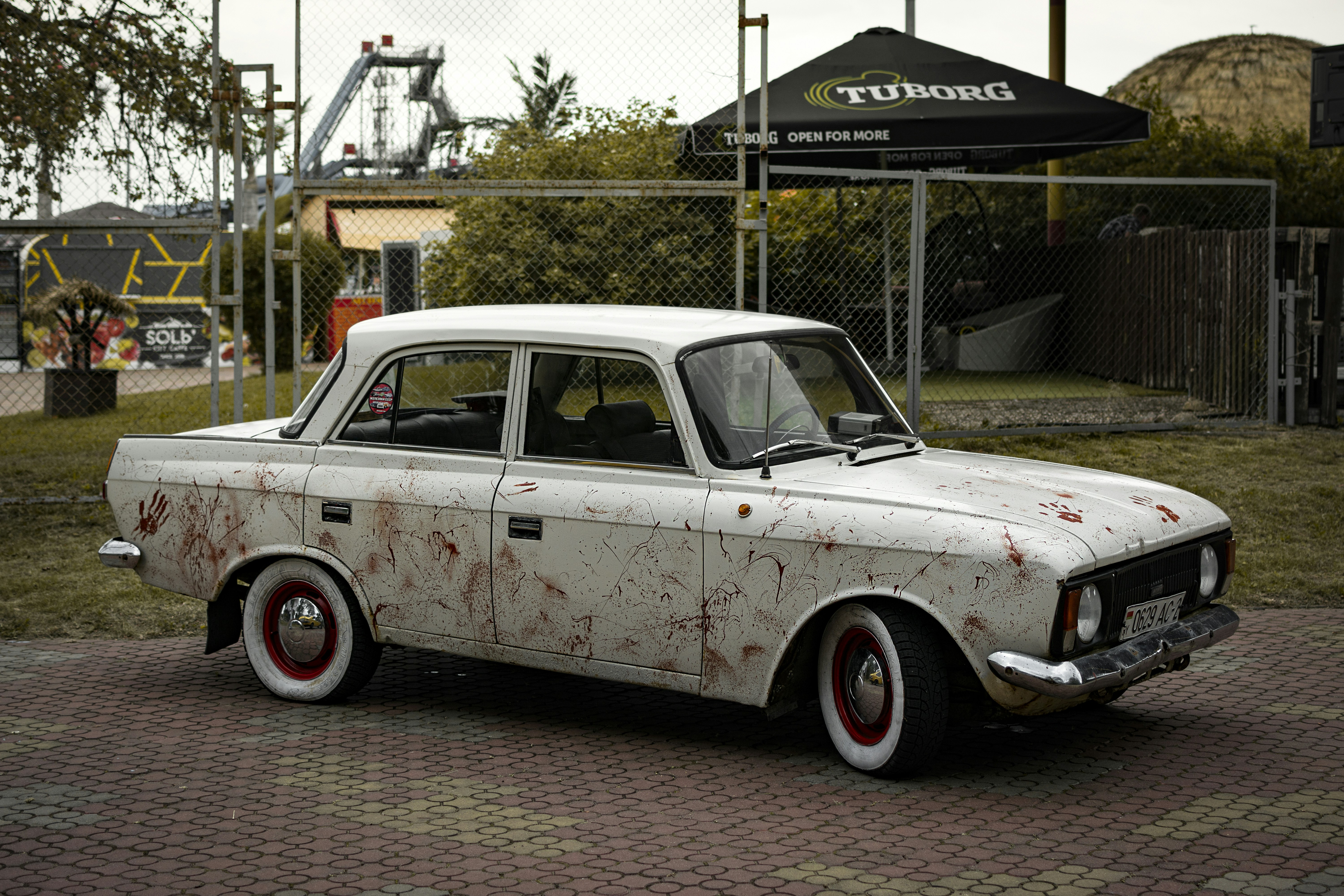 An old white car parked in front of a chain link fence photo – Free ...