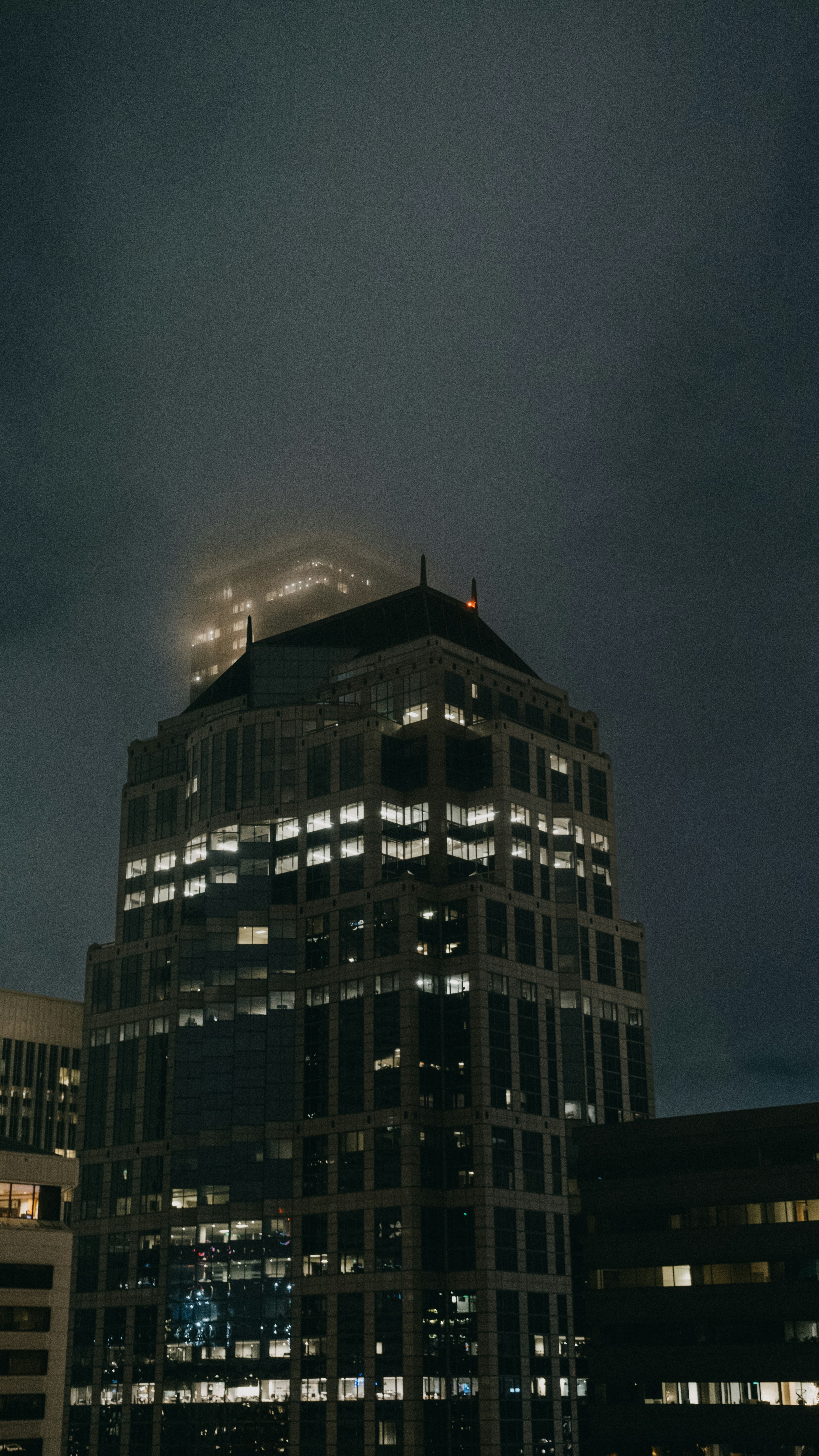Mist-Filtered Pinnacle: A Night-Shrouded Skyscraper Illuminated from Within