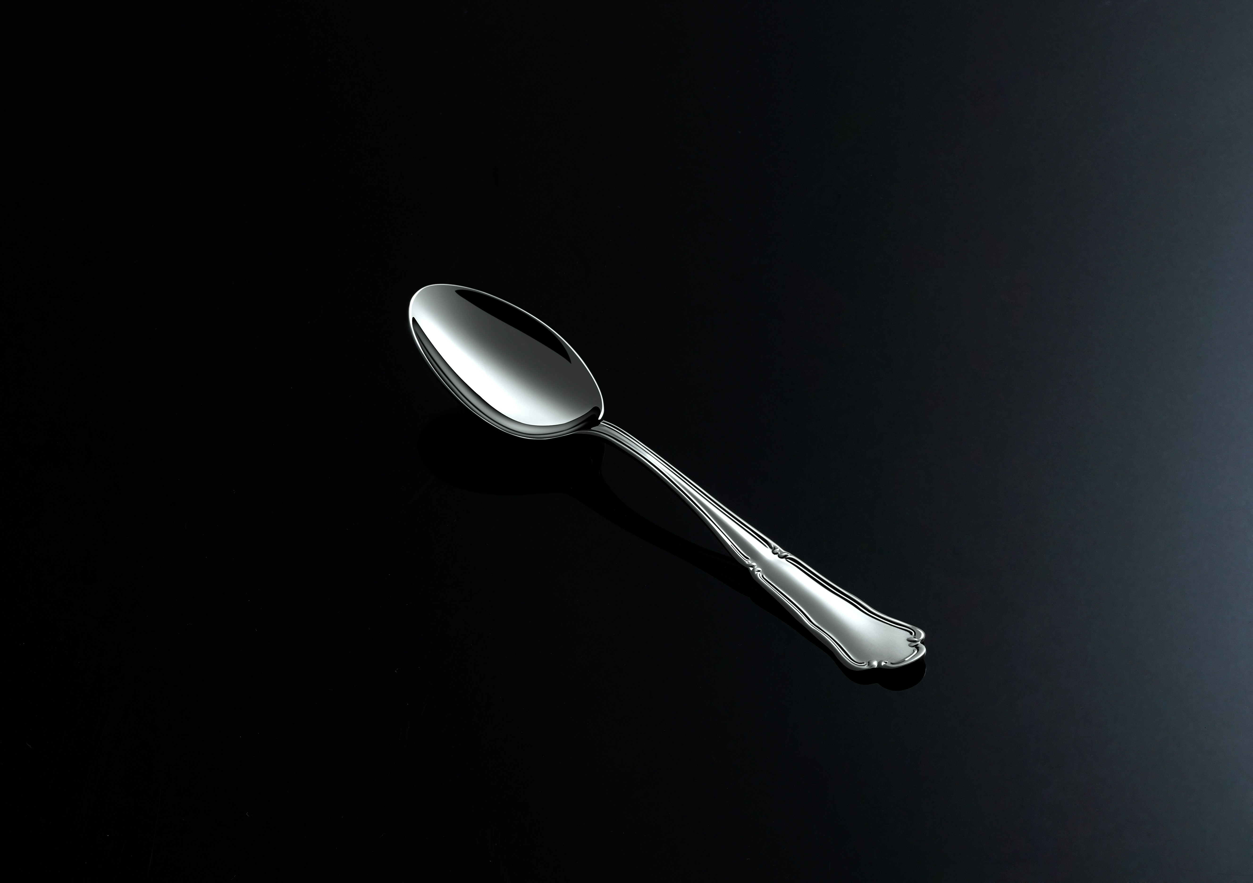 silver spoon | a silver spoon on a black surface