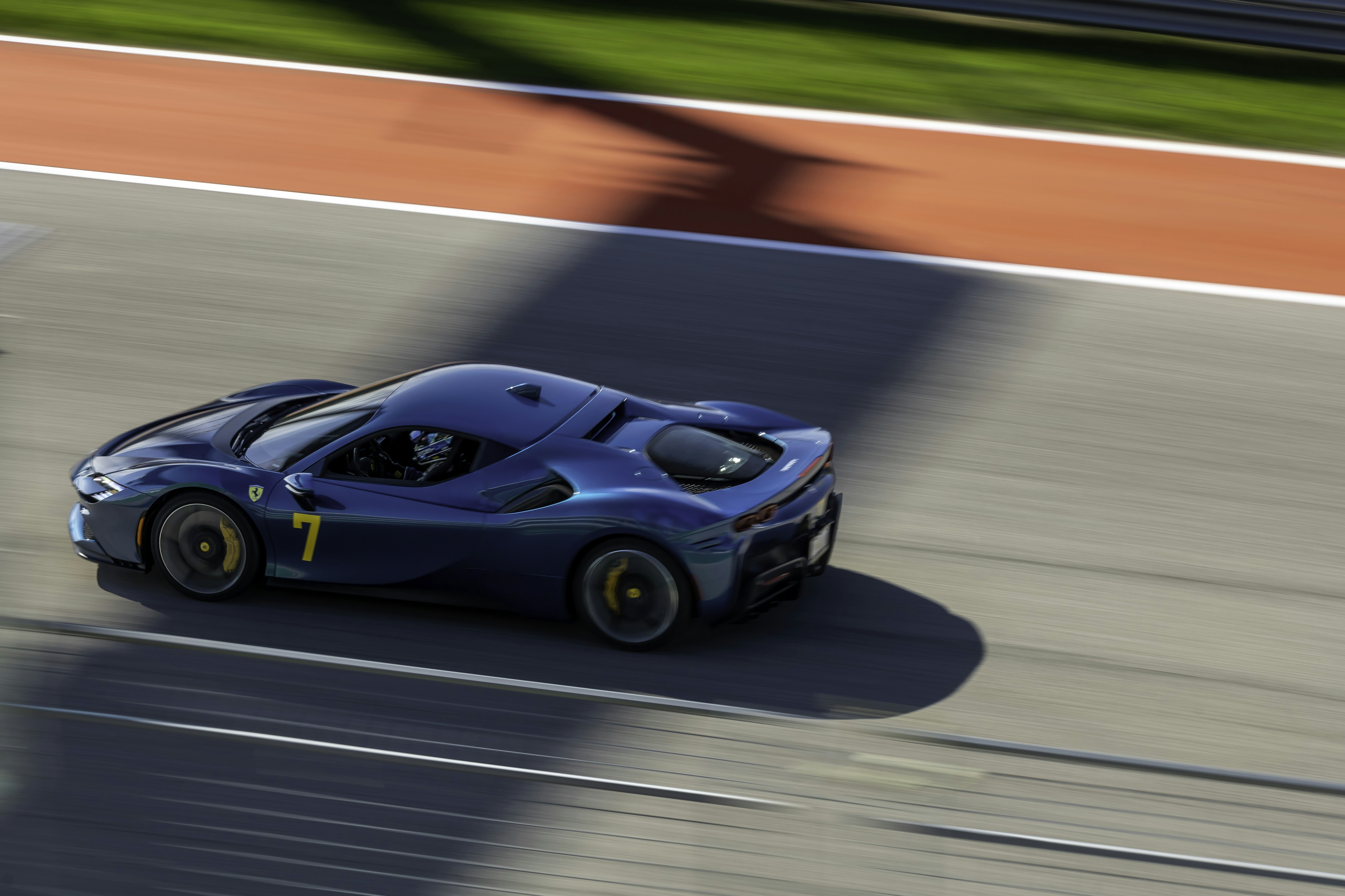 A blue sports car driving down a race track photo – Free Cota Image on ...