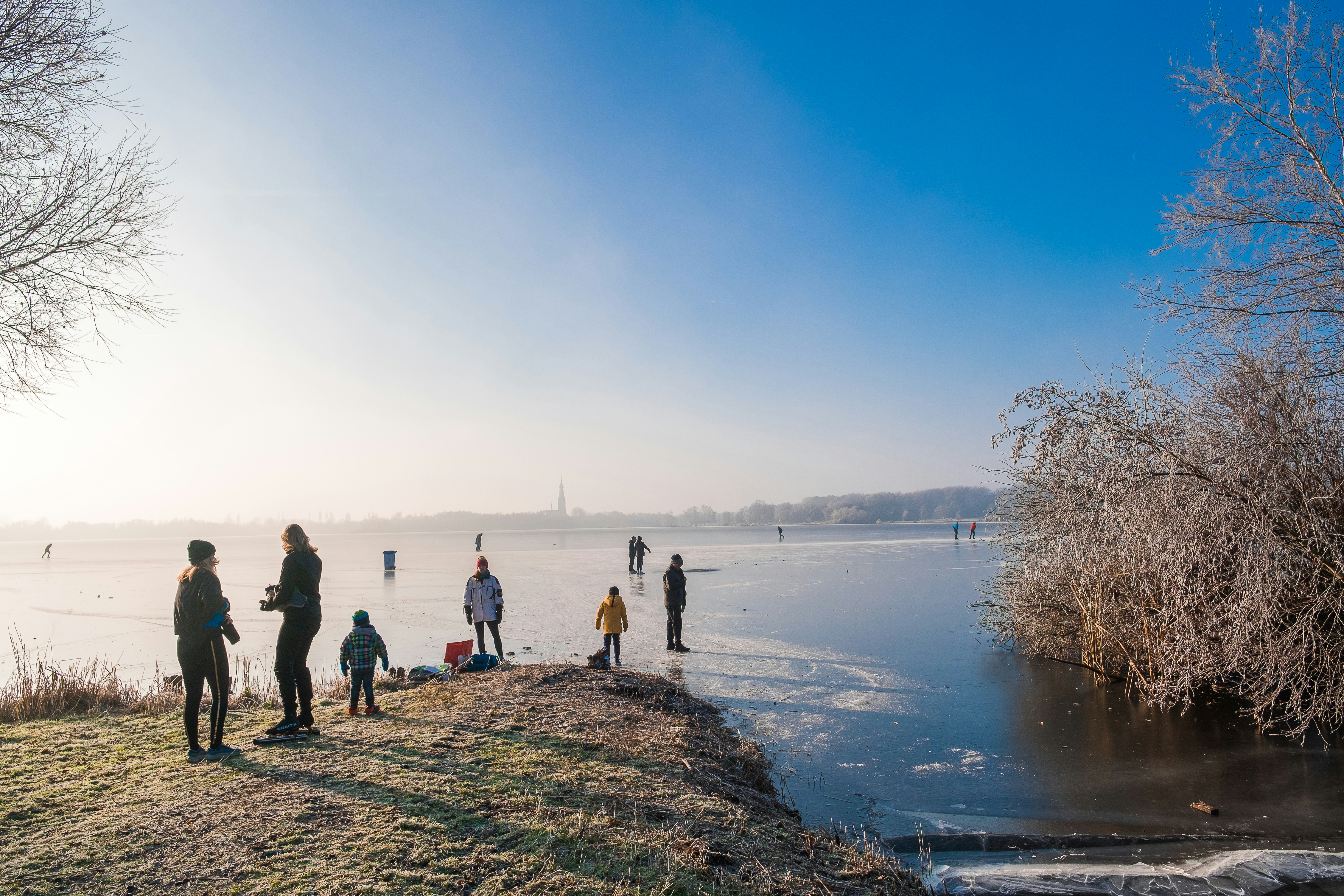 People are getting on the frozen lake to skate
