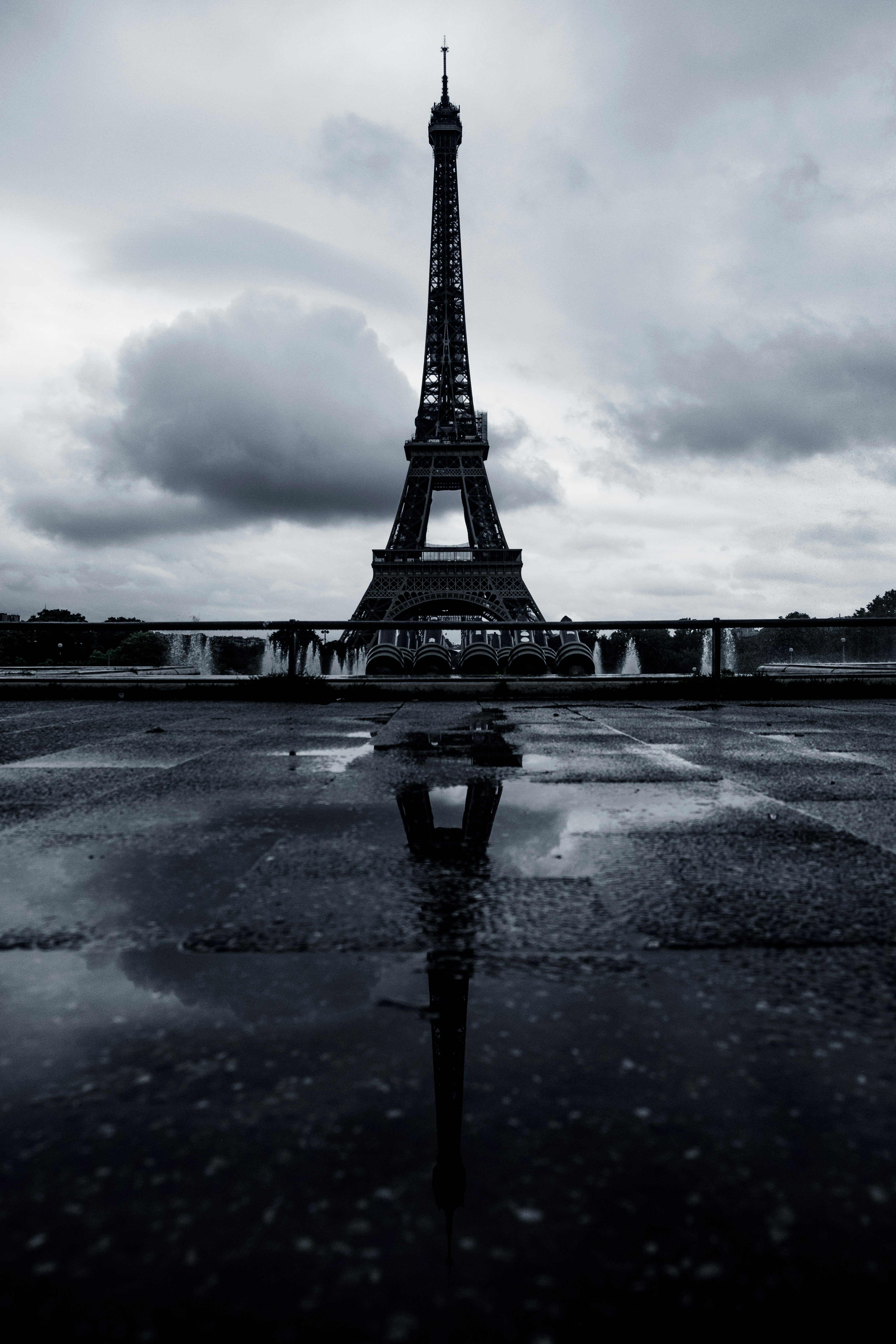Grey Mirror: Eiffel Tower Reflected on a Rain-Washed Paris Plaza
