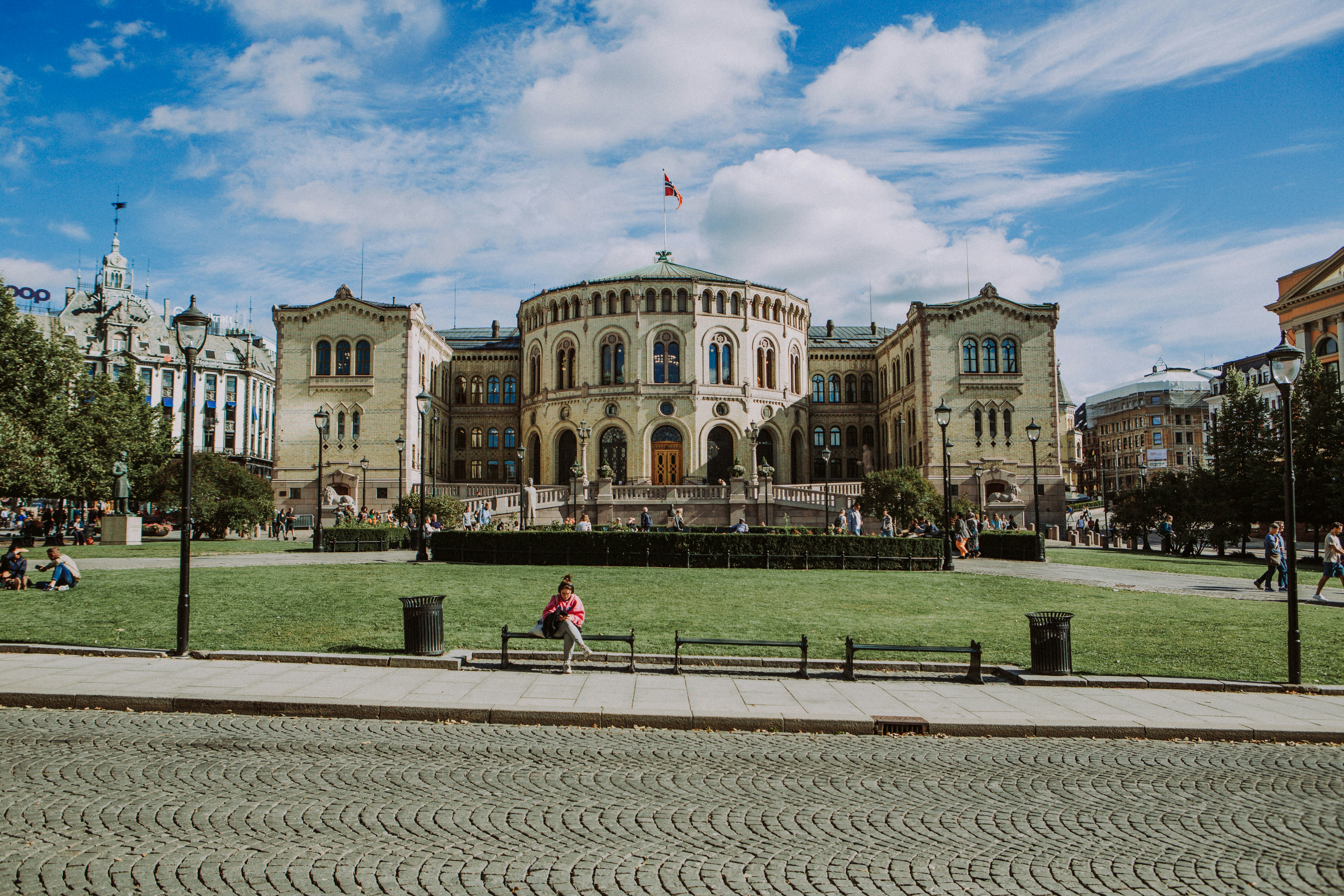 a person walking down a sidewalk in front of a large building
