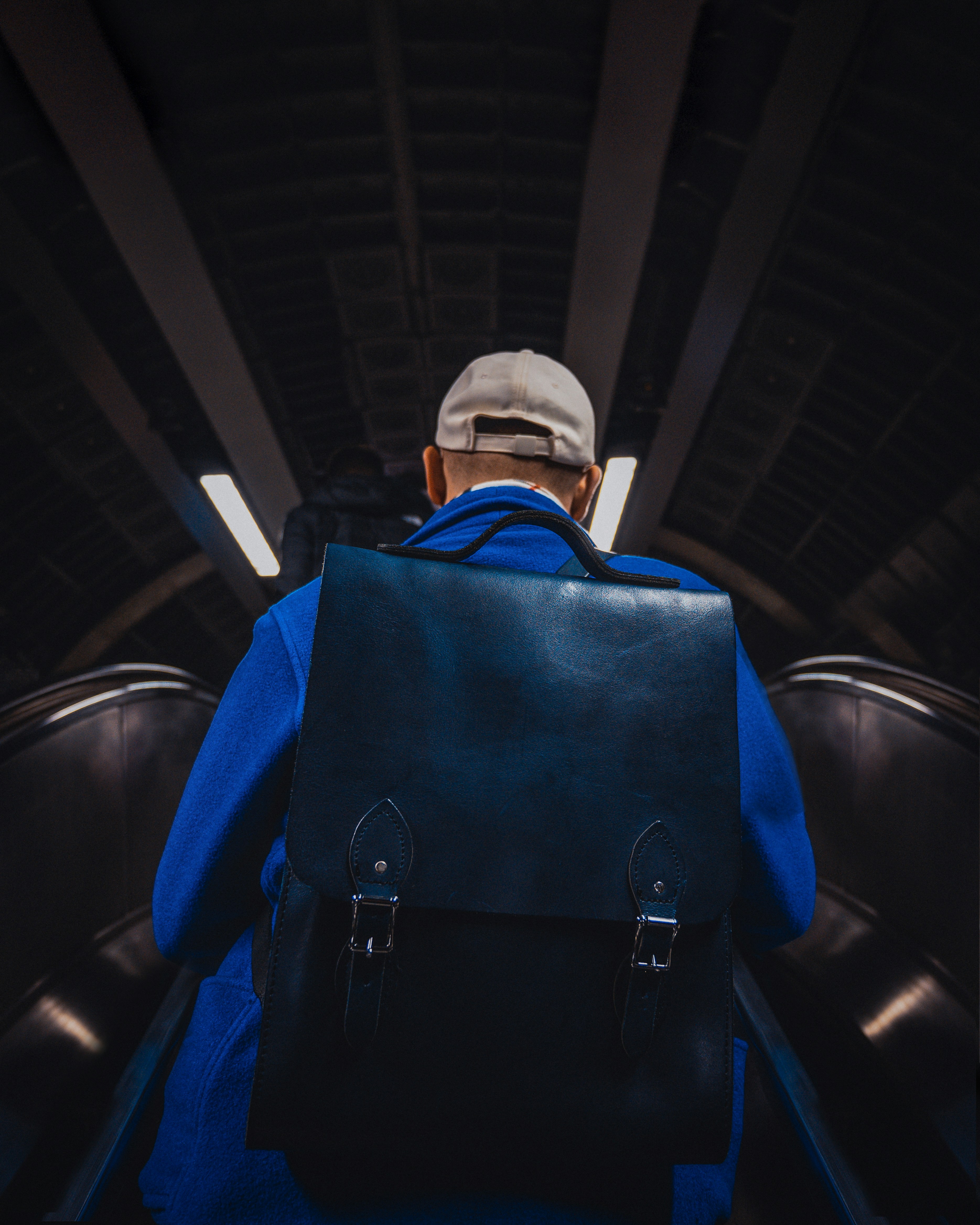 Midnight Ascent: The Blue Backpack on the Subway Escalator