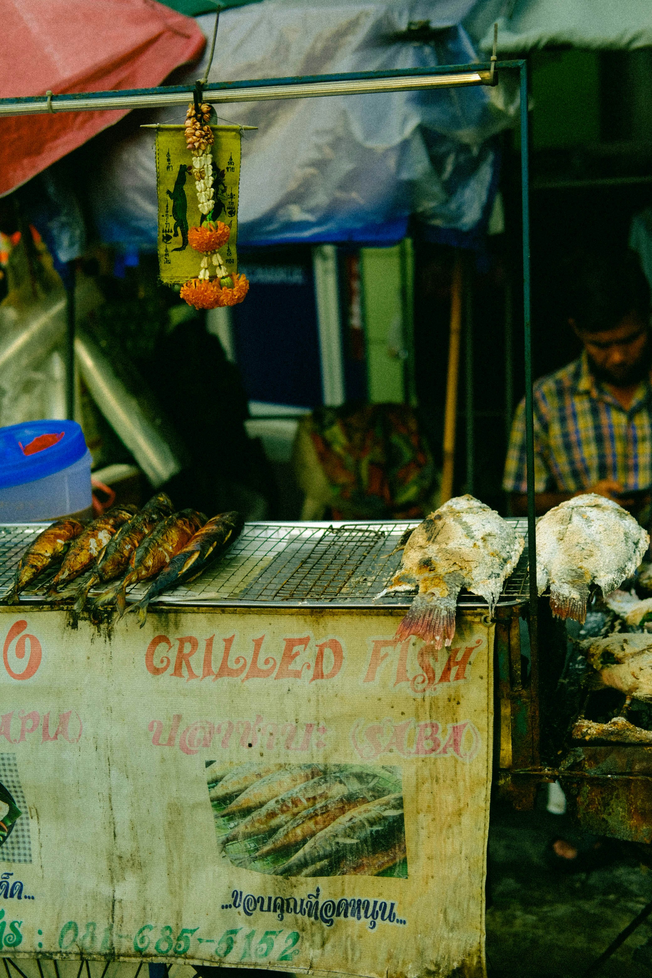 a man standing in front of a food stand