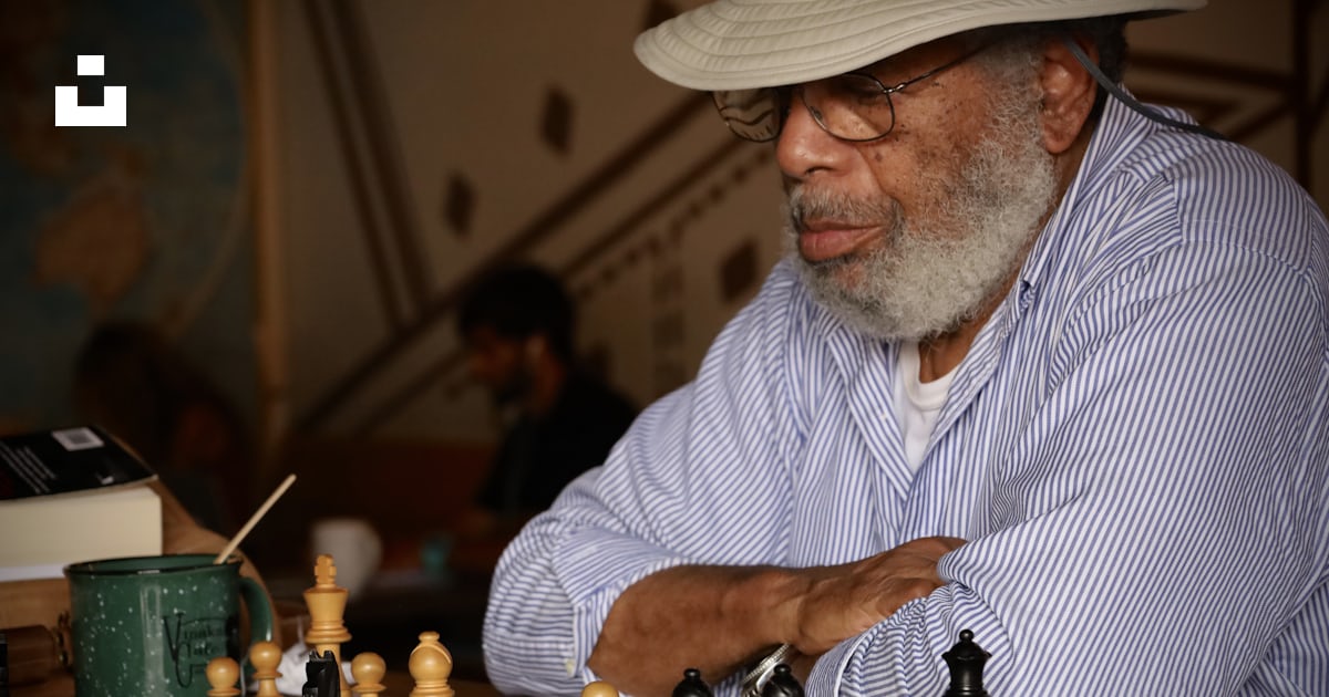 Un hombre mayor jugando al ajedrez con un gran conjunto de piezas de ... Un hombre mayor jugando al ajedrez con un gran conjunto de piezas de ...