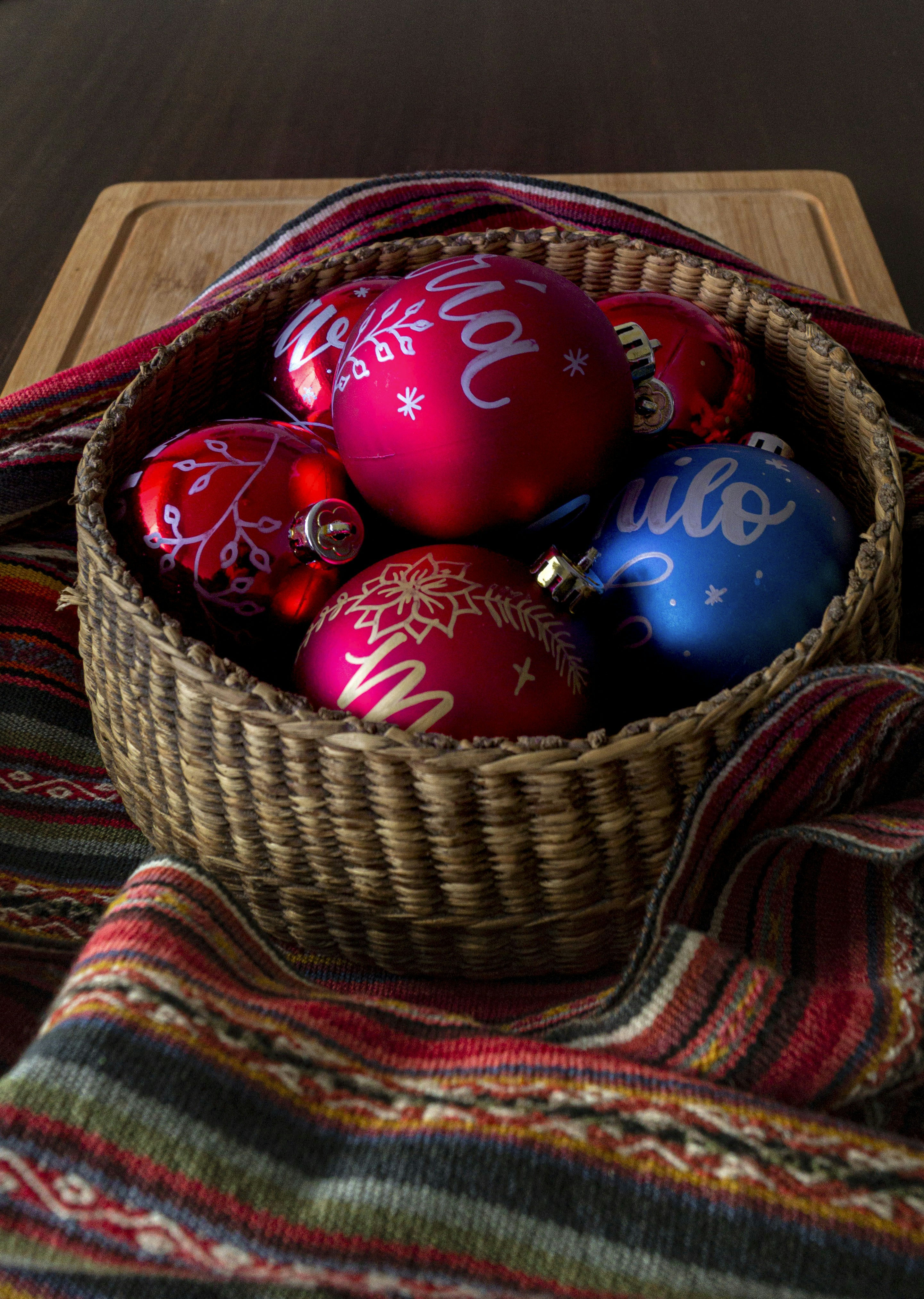 Crimson Ornaments Nestled in a Woven Basket: A Quiet Holiday Still Life