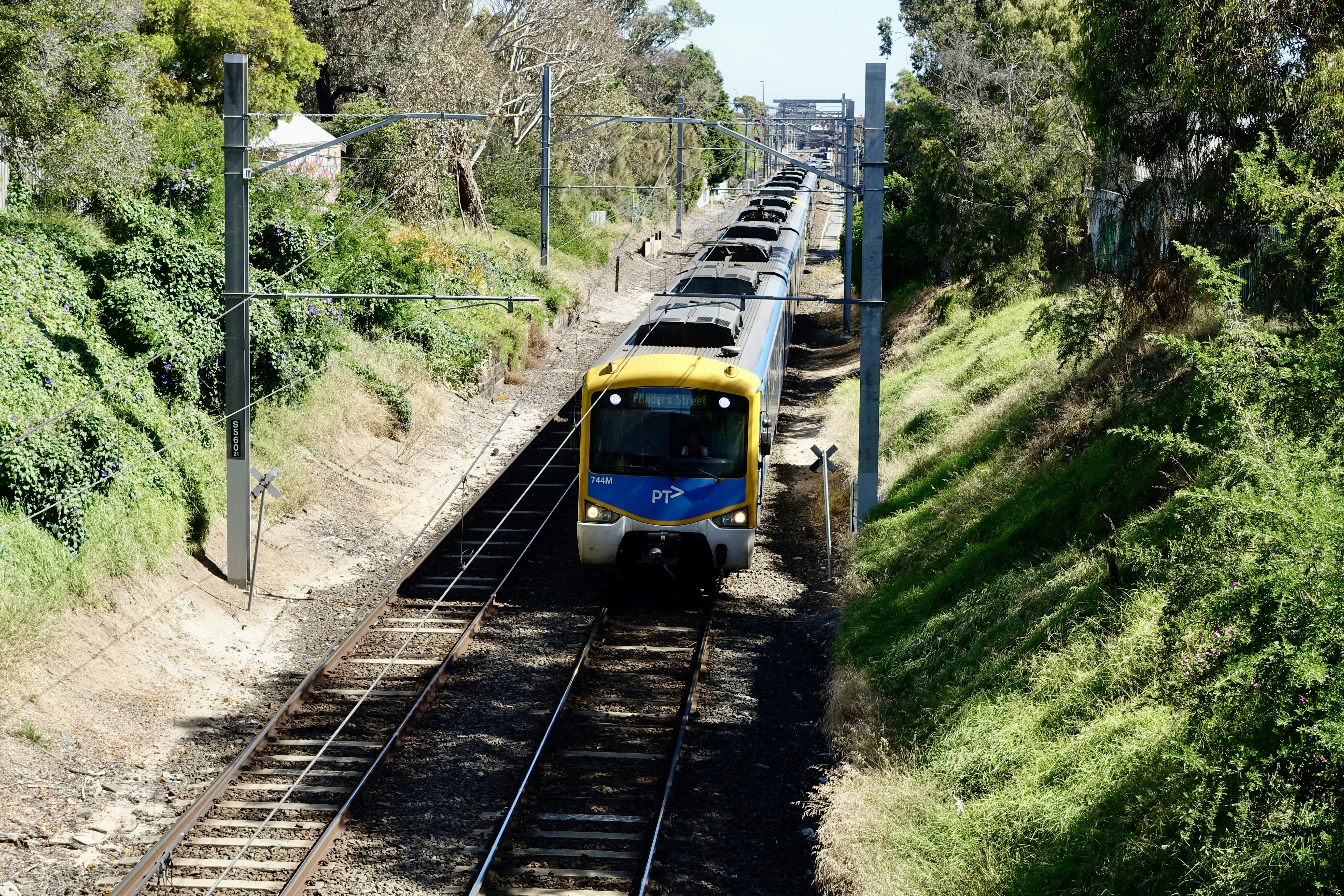 A yellow and blue train traveling down train tracks photo – Free ...