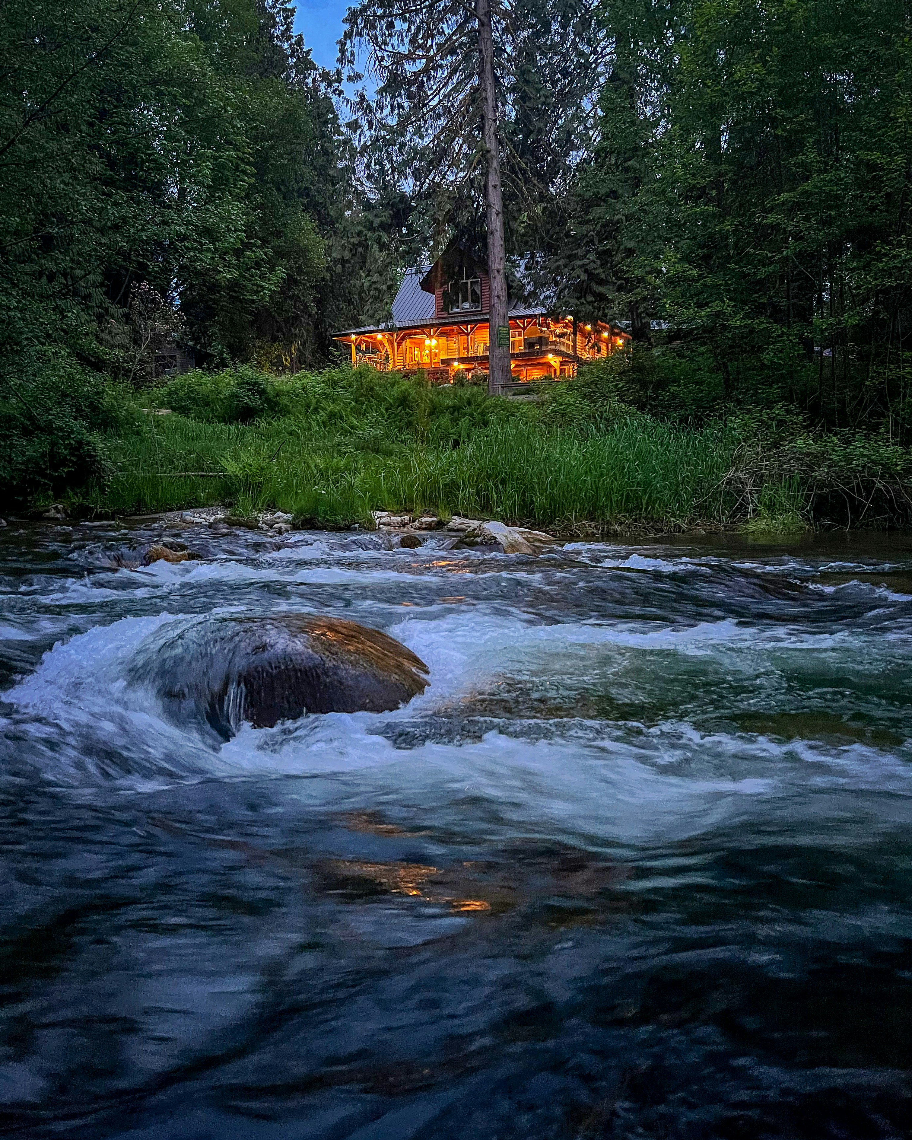 Warm Glow in the Rapids: A Forest Cabin at Dusk