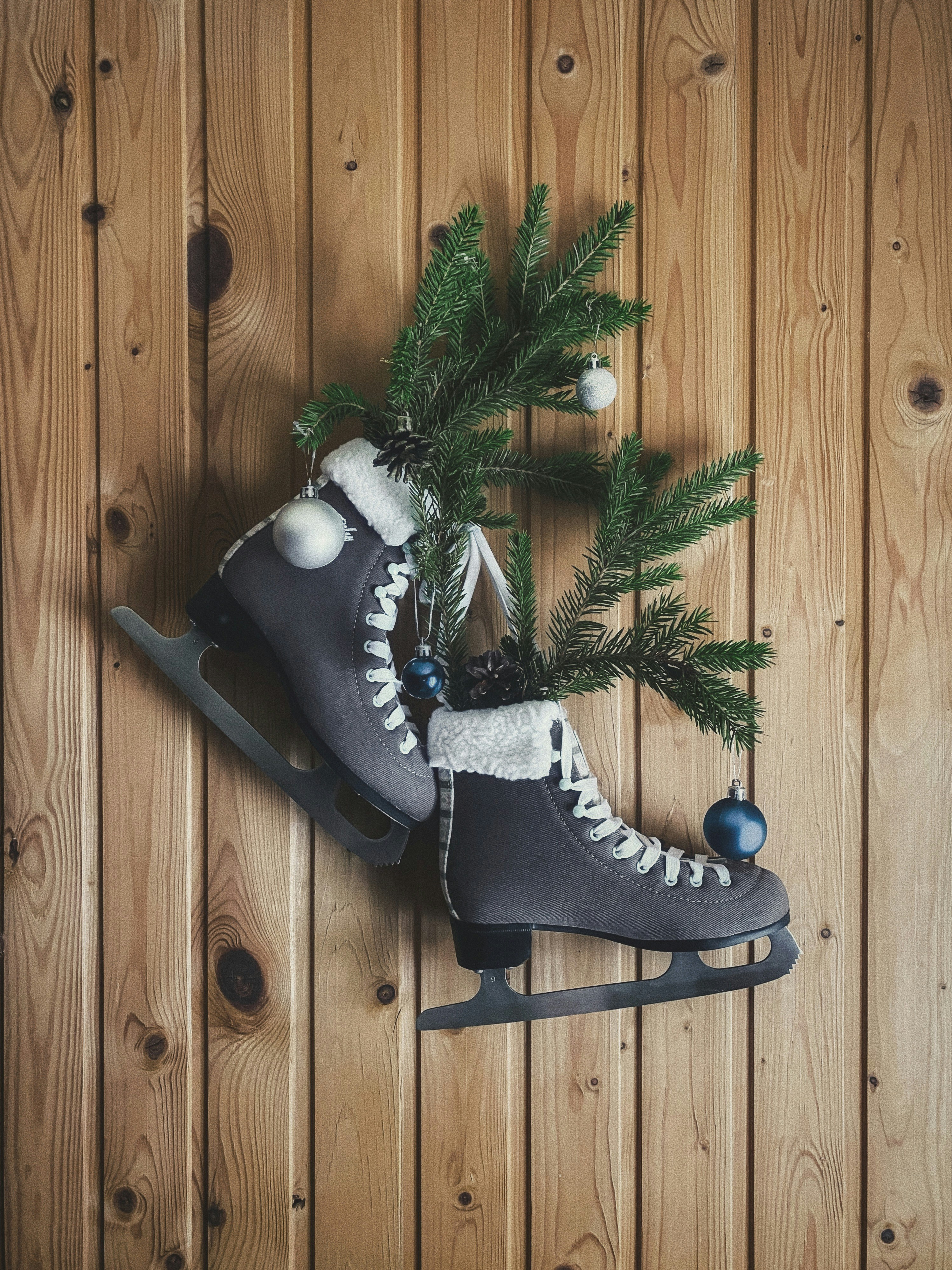 Rustic Winter Still-Life: Ice Skates, Pine Boughs, and Blue Ornaments on Wood